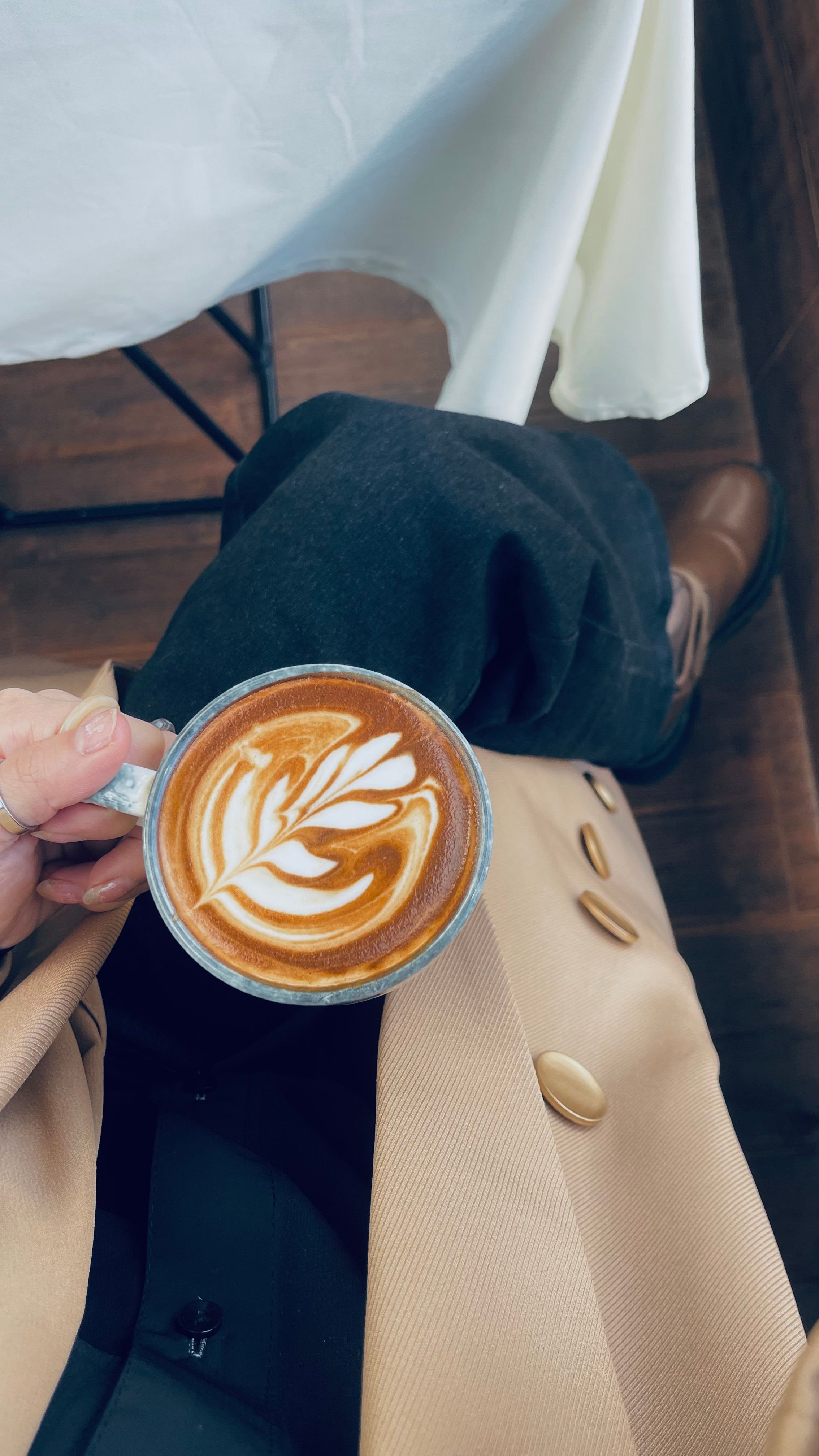 Person Enjoying Coffee with Latte Art in Cozy Cafe · Free Stock Photo