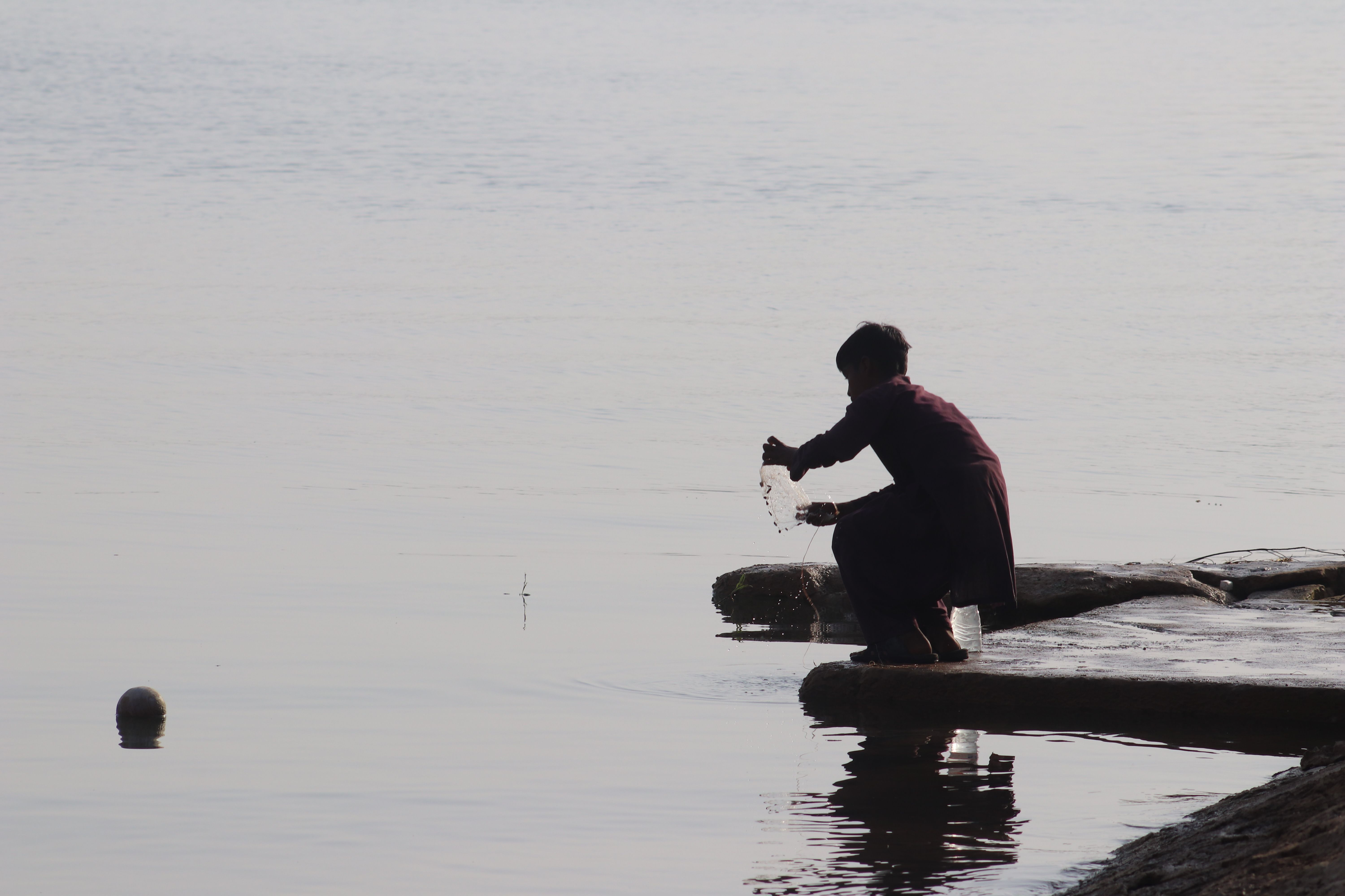Silhouette of a Child by Tranquil Lakeside · Free Stock Photo