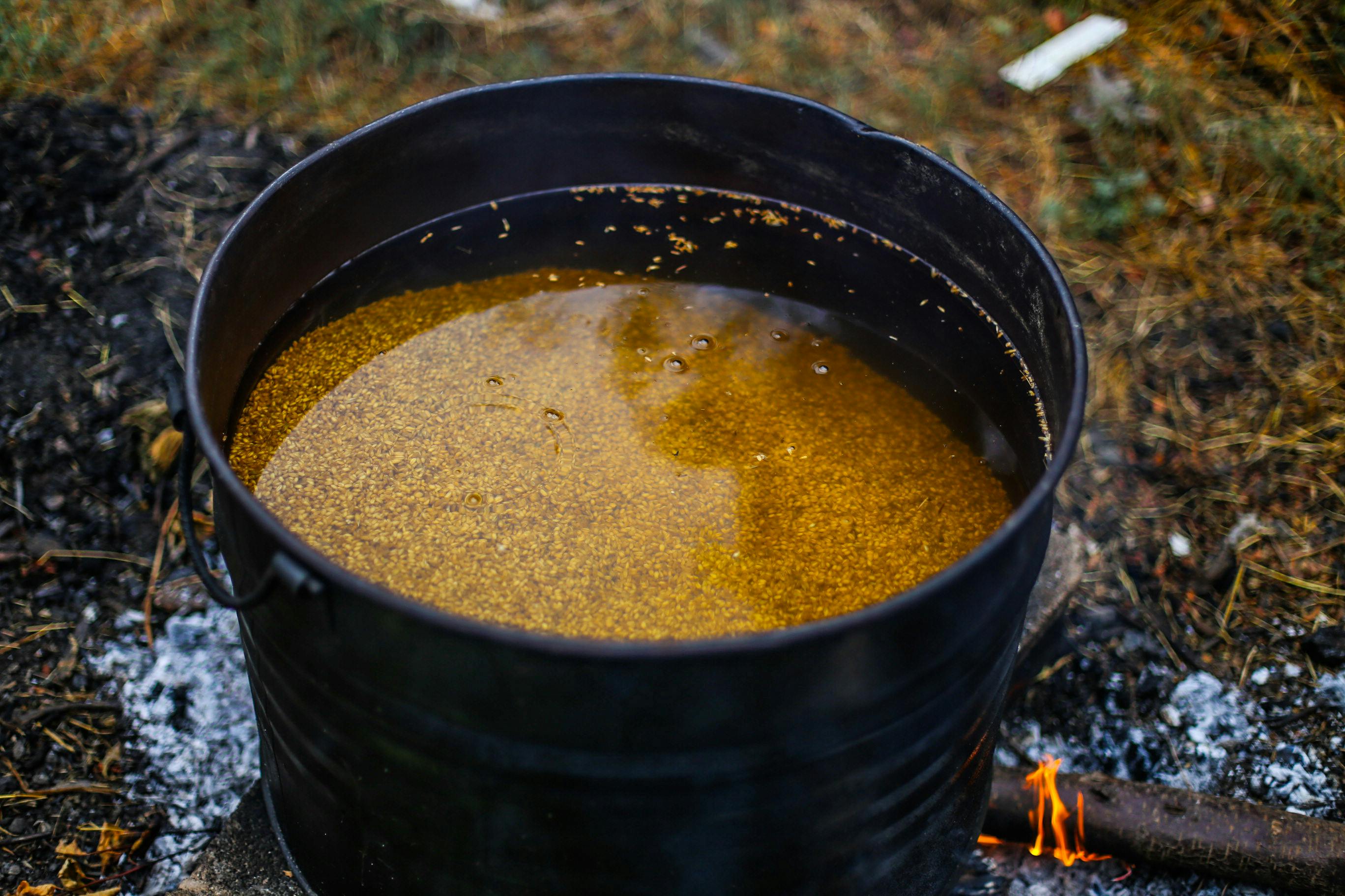 Large outdoor cauldron boiling over a fire · Free Stock Photo