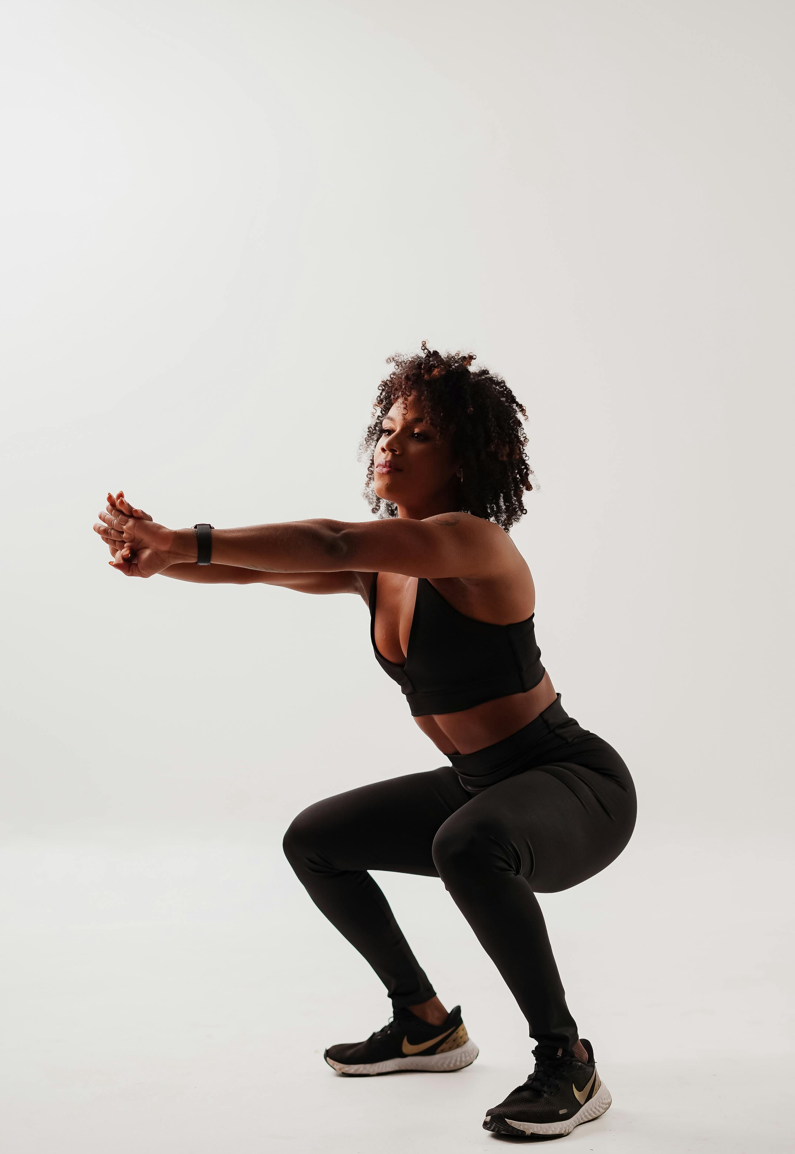 Fit woman performing squats during workout · Free Stock Photo