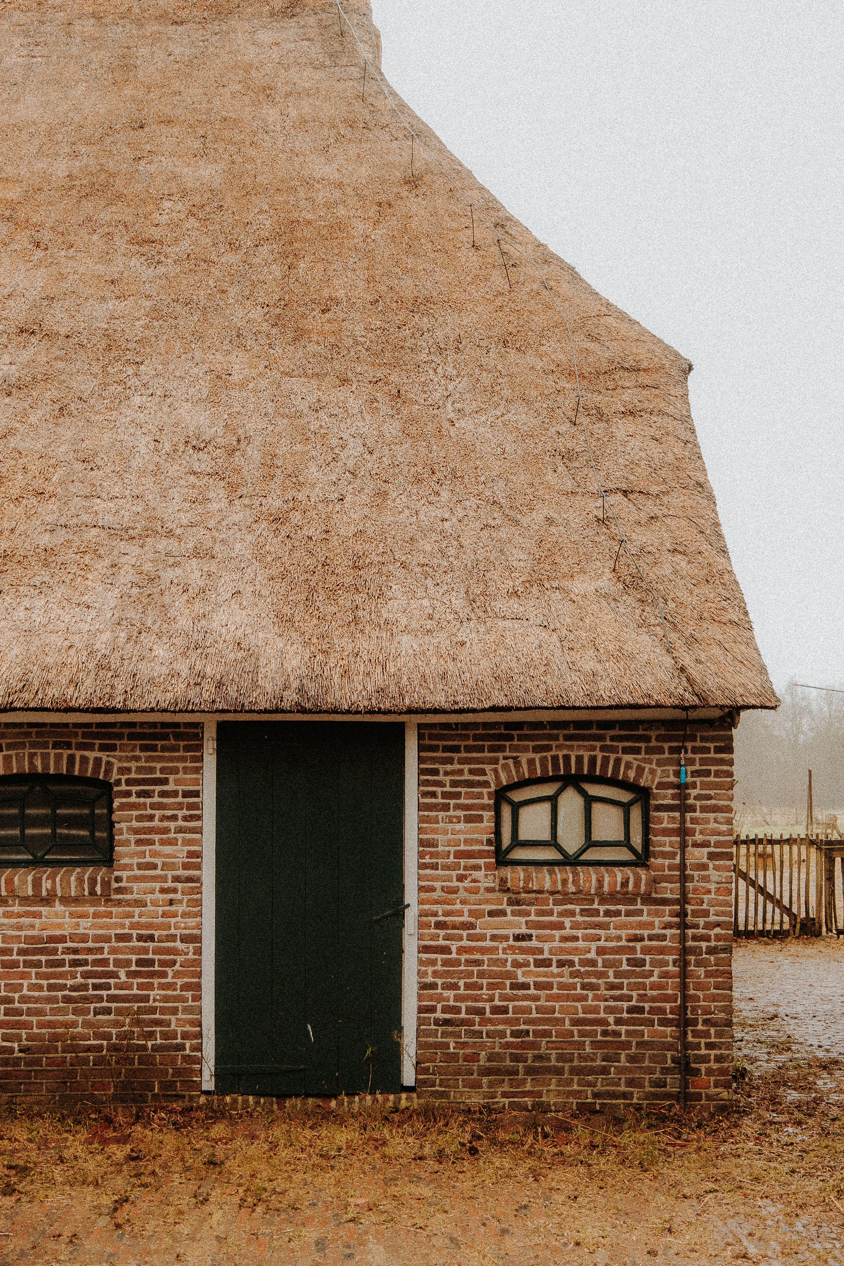 Charming Thatched Roof Cottage in Rustic Setting · Free Stock Photo