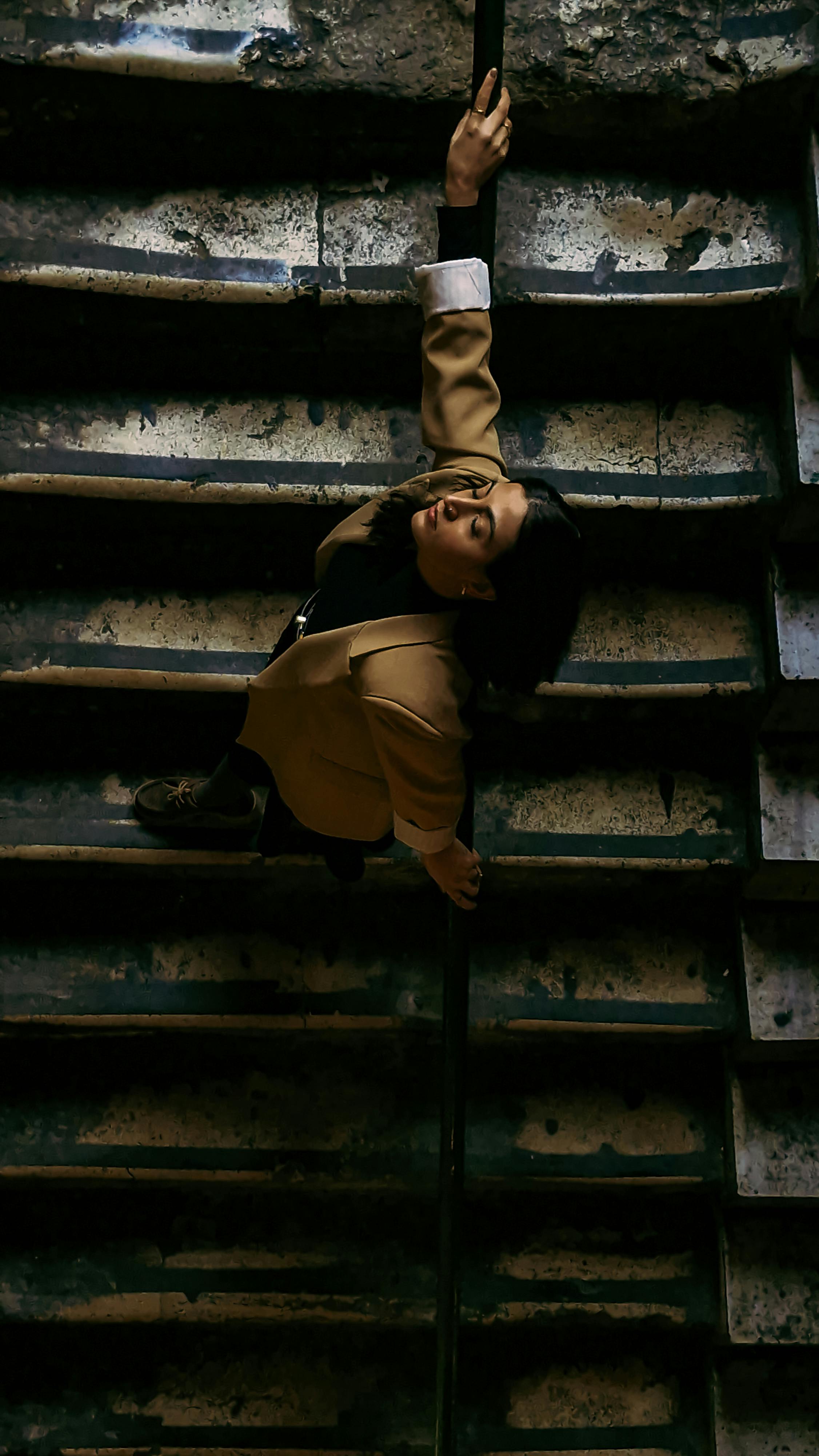 Woman in Tan Coat Ascending Rusty Staircase in İstanbul · Free Stock Photo