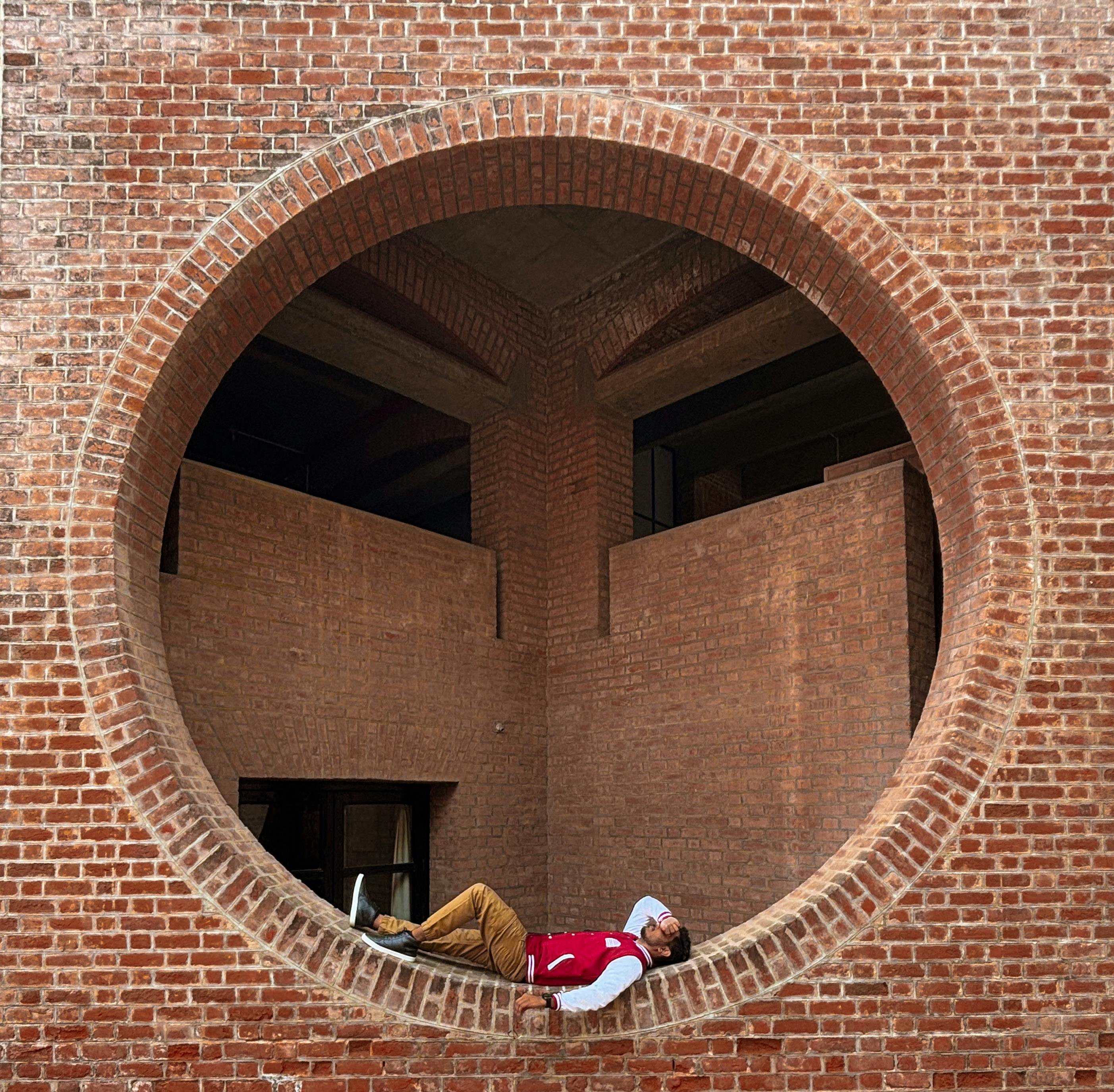 Man Relaxing in Circular Brick Structure · Free Stock Photo
