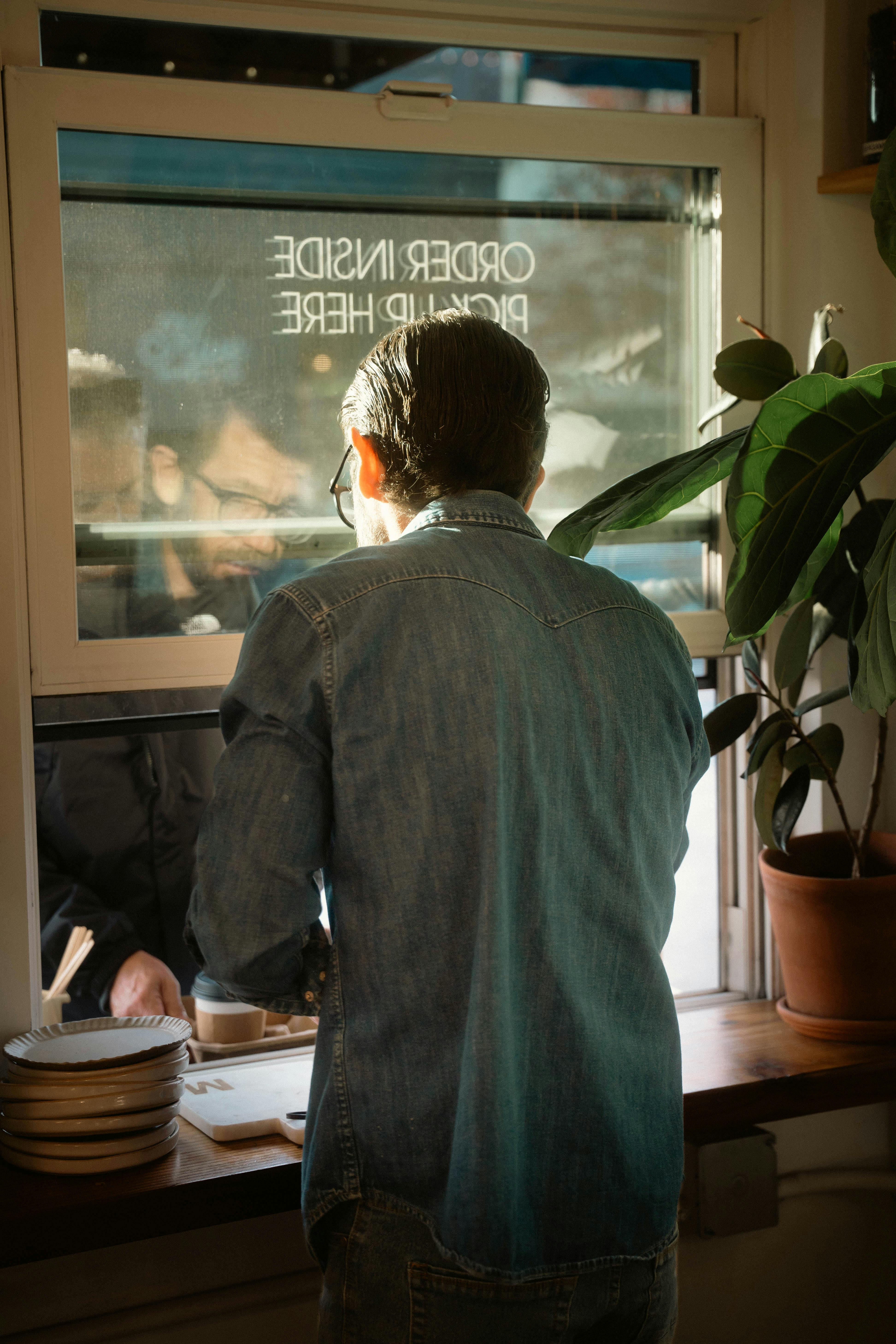 Casual cafe customer at pick-up window · Free Stock Photo