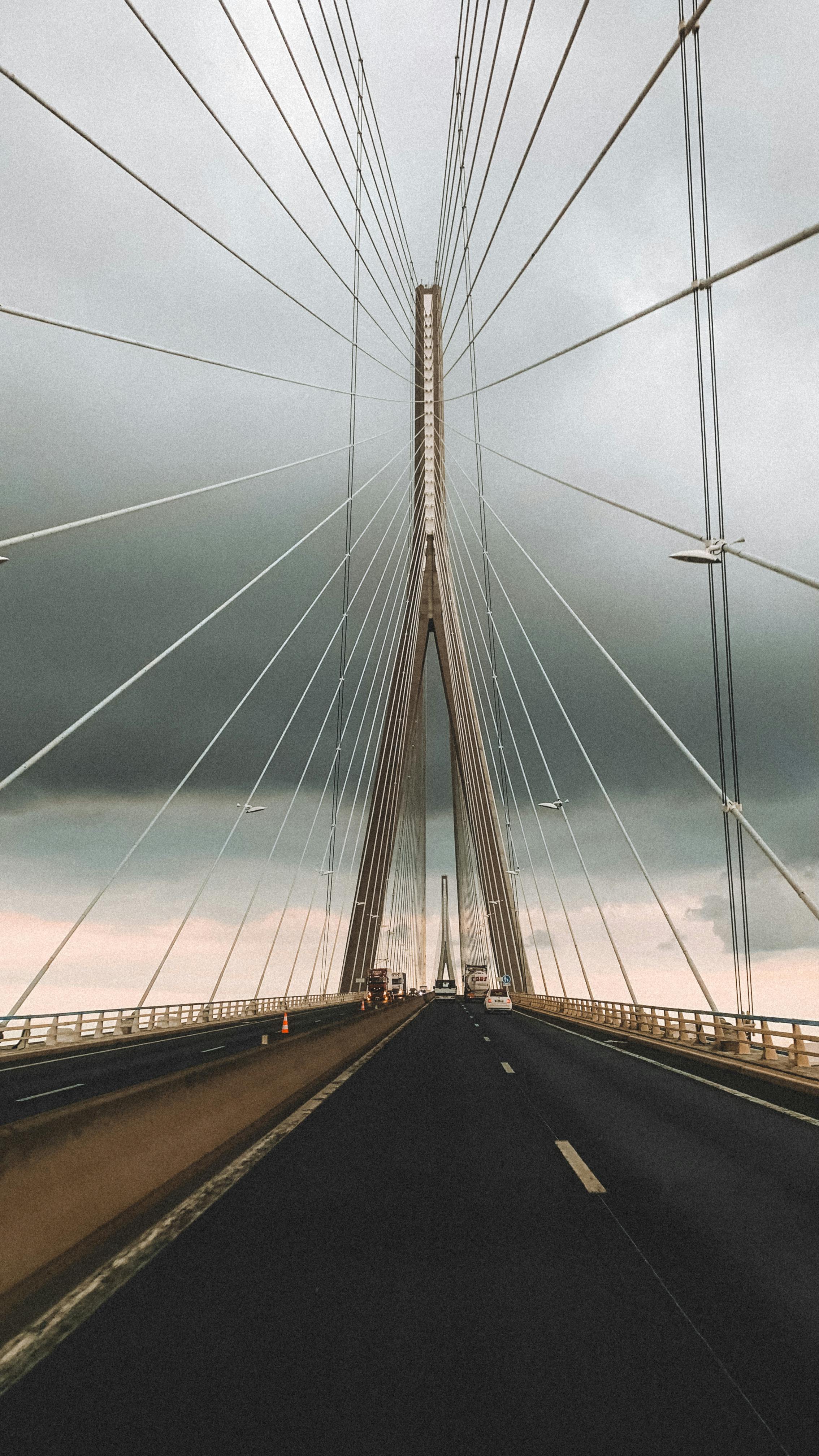 Dramatic Suspension Bridge Under Moody Skies · Free Stock Photo