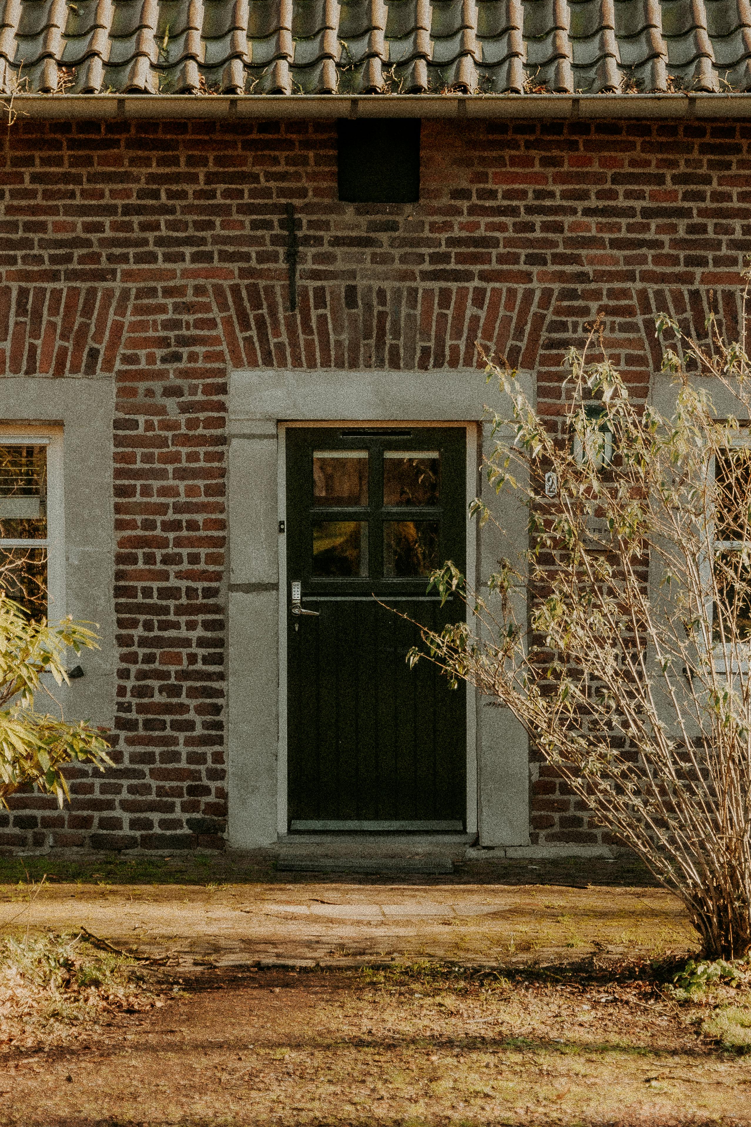 Charming Brick Cottage Entrance in Sunlit Garden · Free Stock Photo