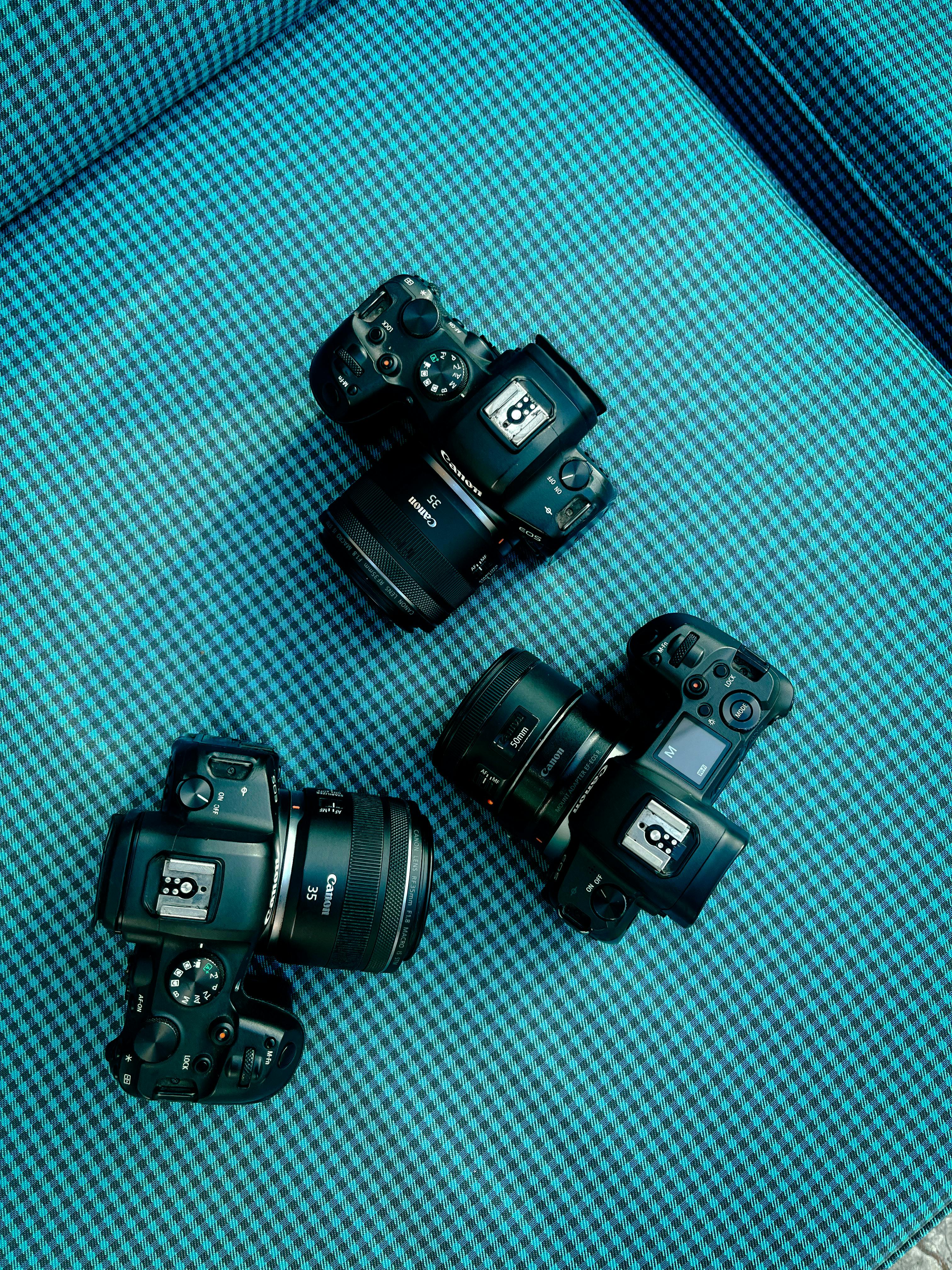 Top View of Three DSLR Cameras on Teal Fabric · Free Stock Photo