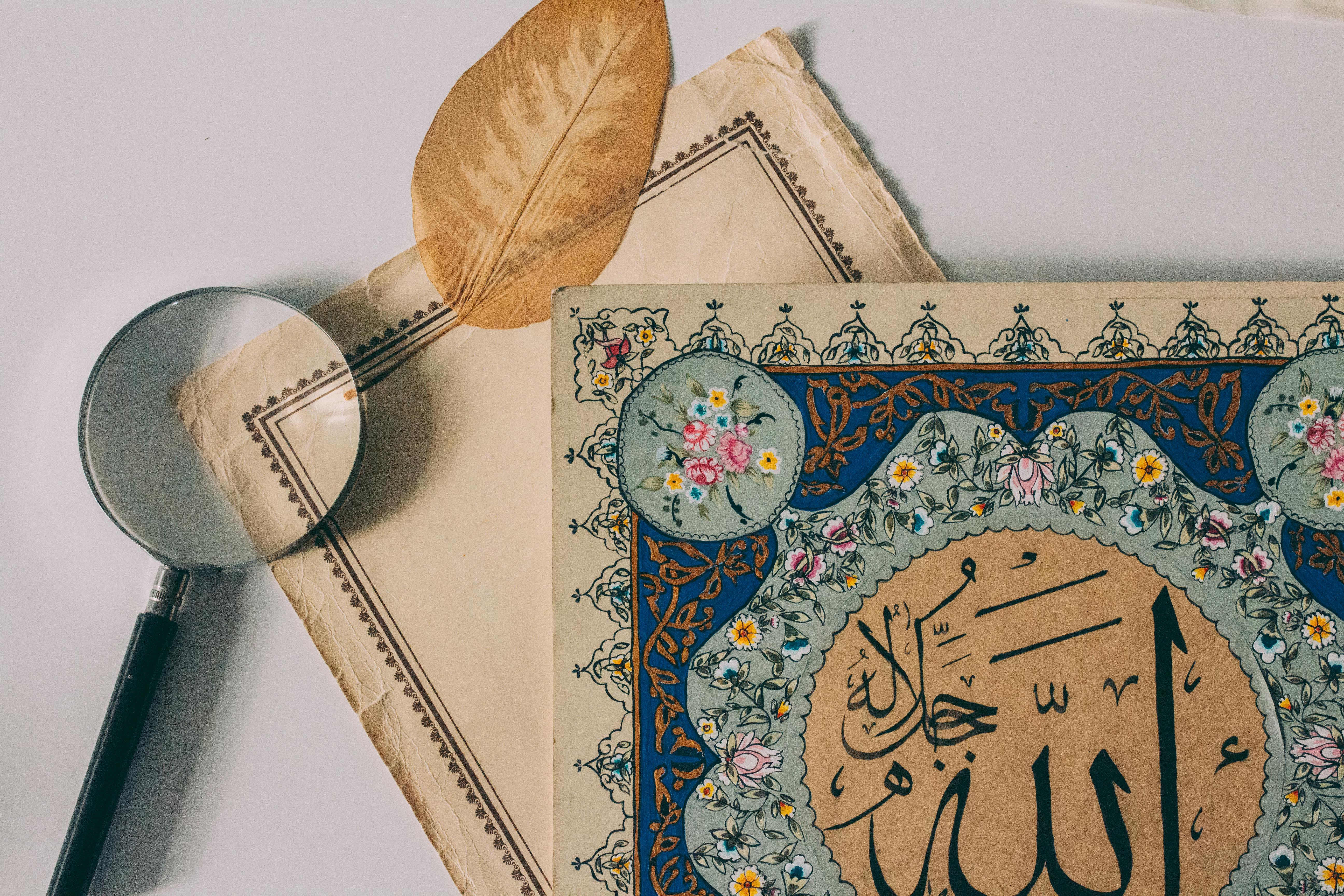 Exquisite Islamic Calligraphy with Magnifying Glass · Free Stock Photo