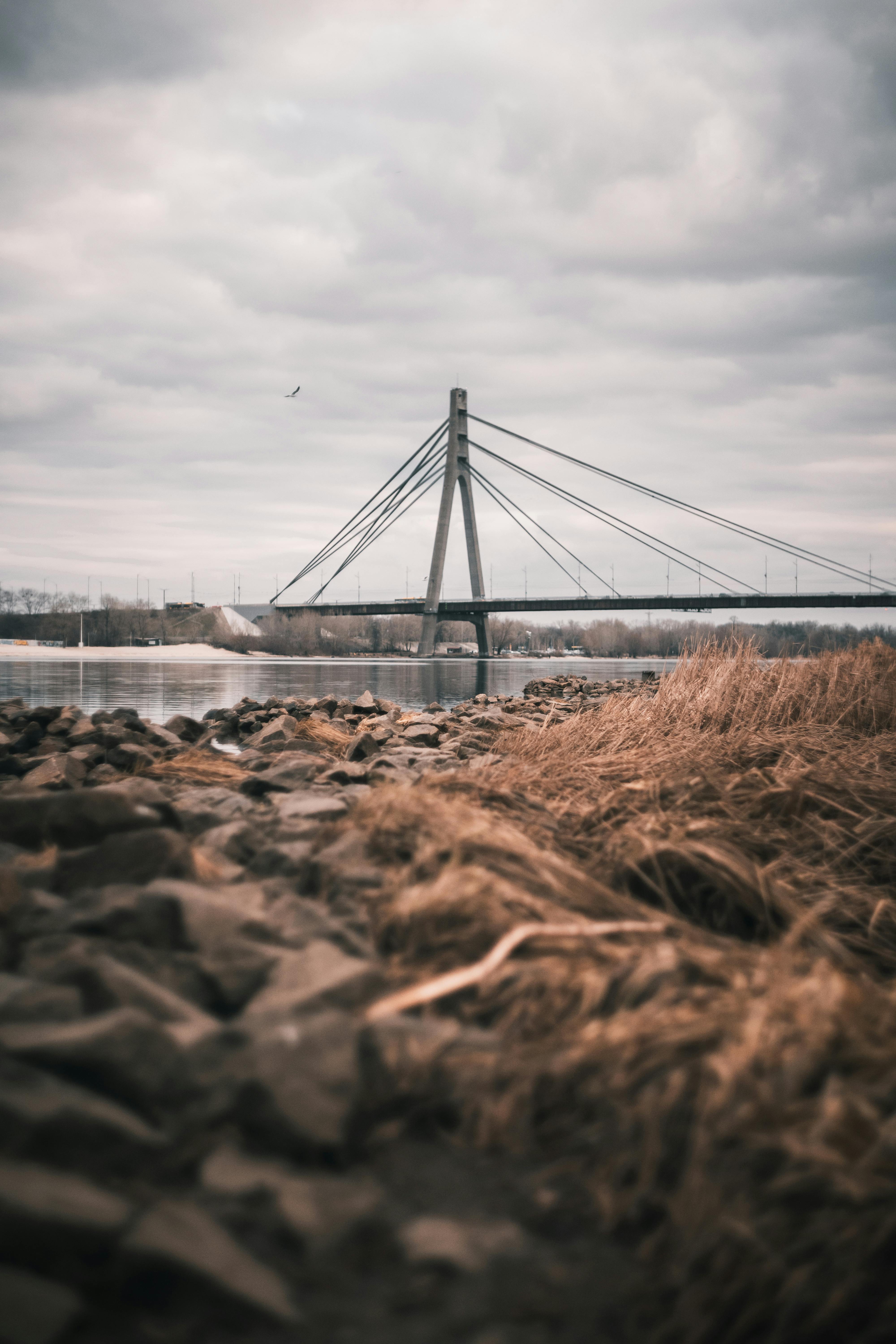 Moody Bridge Over River with Cloudy Sky · Free Stock Photo