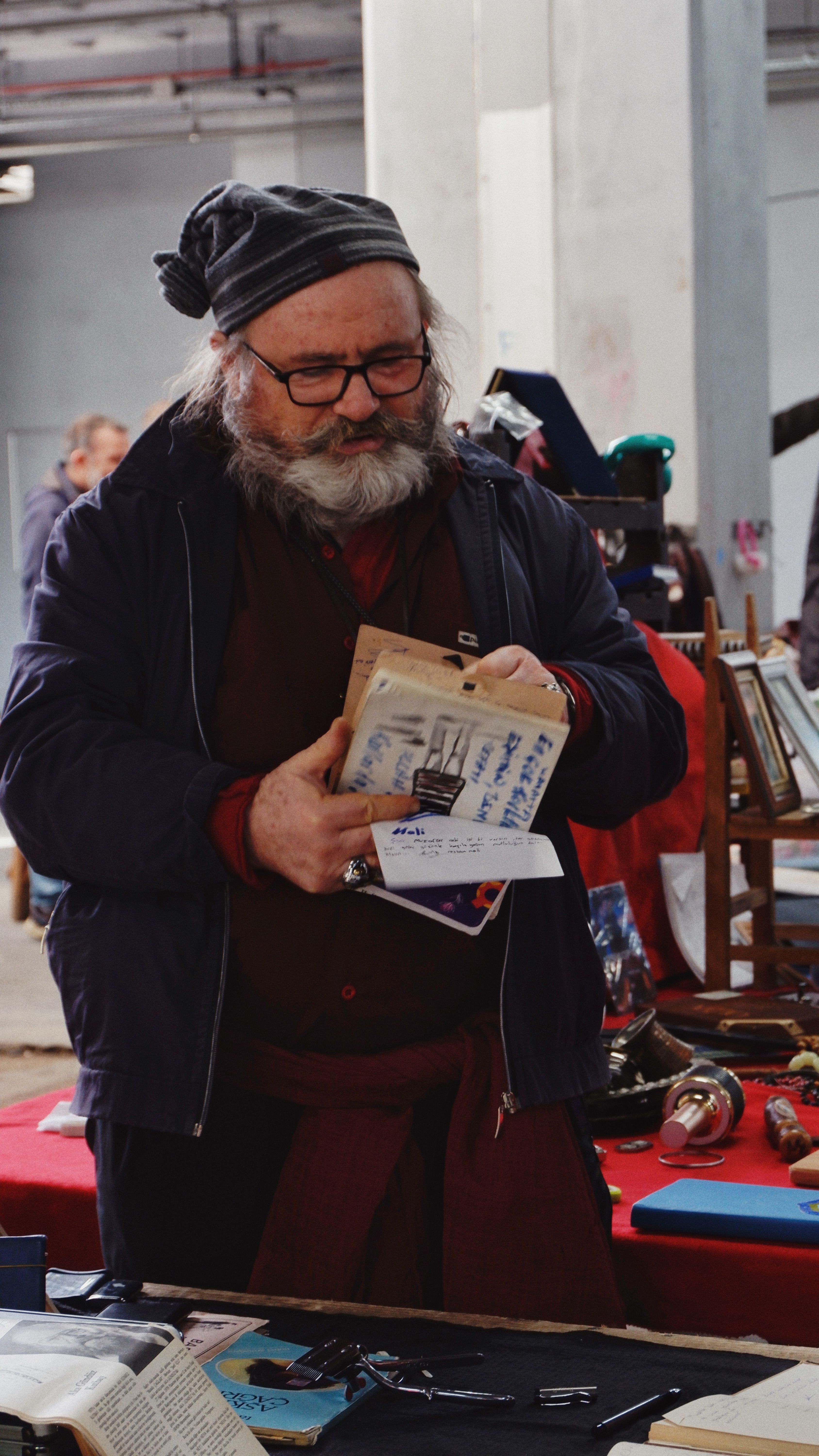 Elderly Man Browsing Antique Books at Market · Free Stock Photo