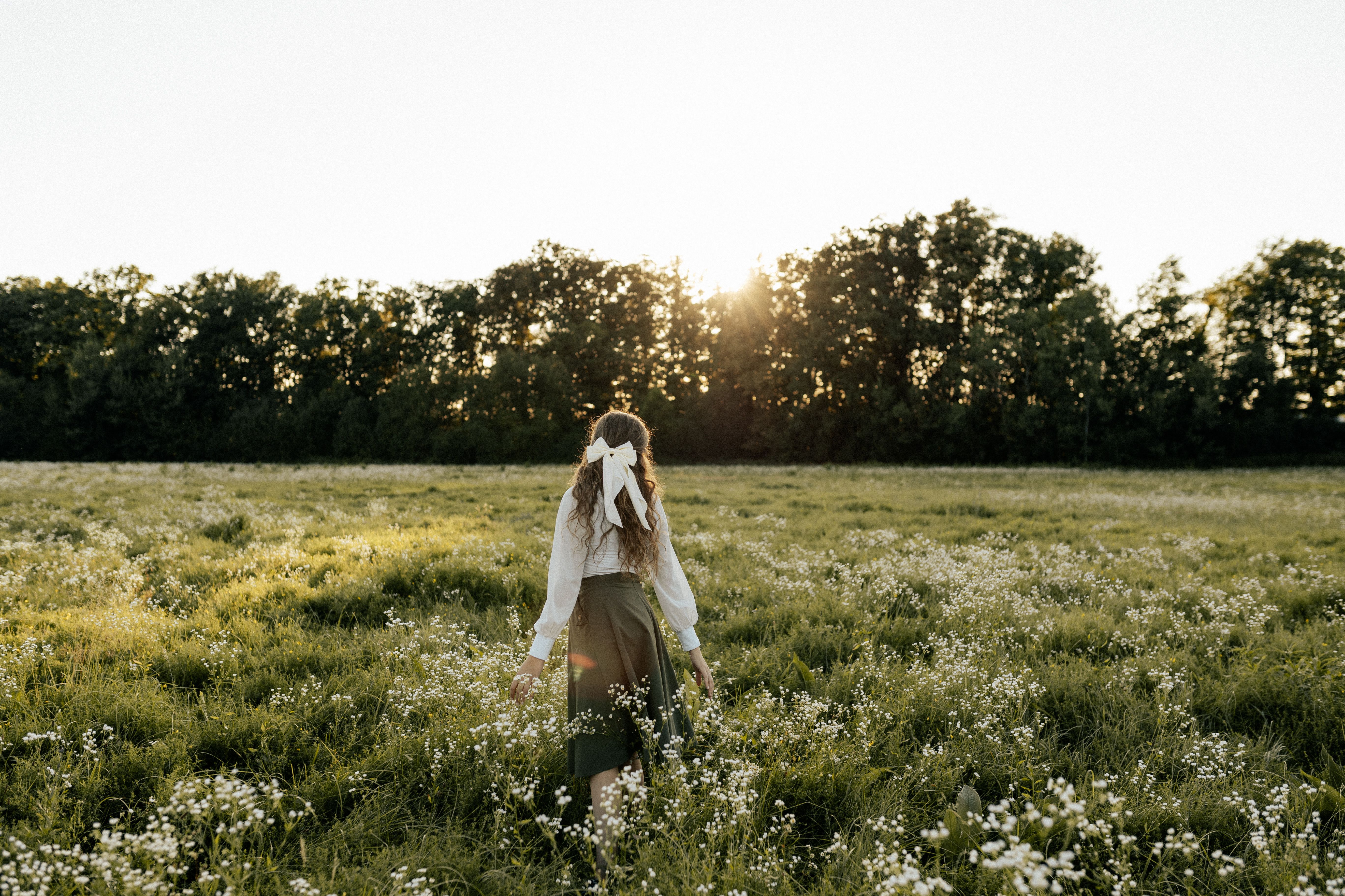 Woman Walking in Flower Field at Sunset · Free Stock Photo