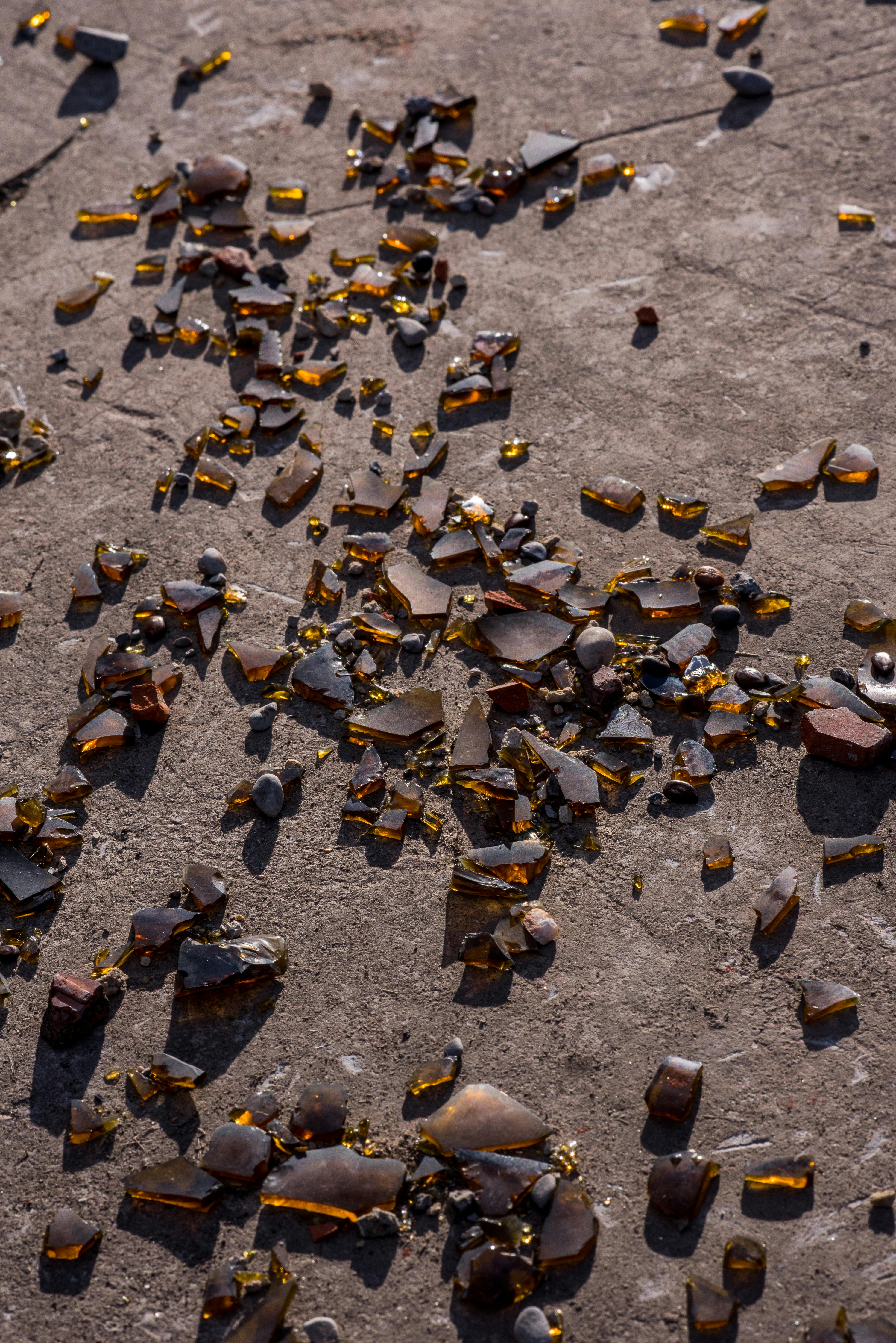 Scattered Shards of Brown Glass on Concrete · Free Stock Photo