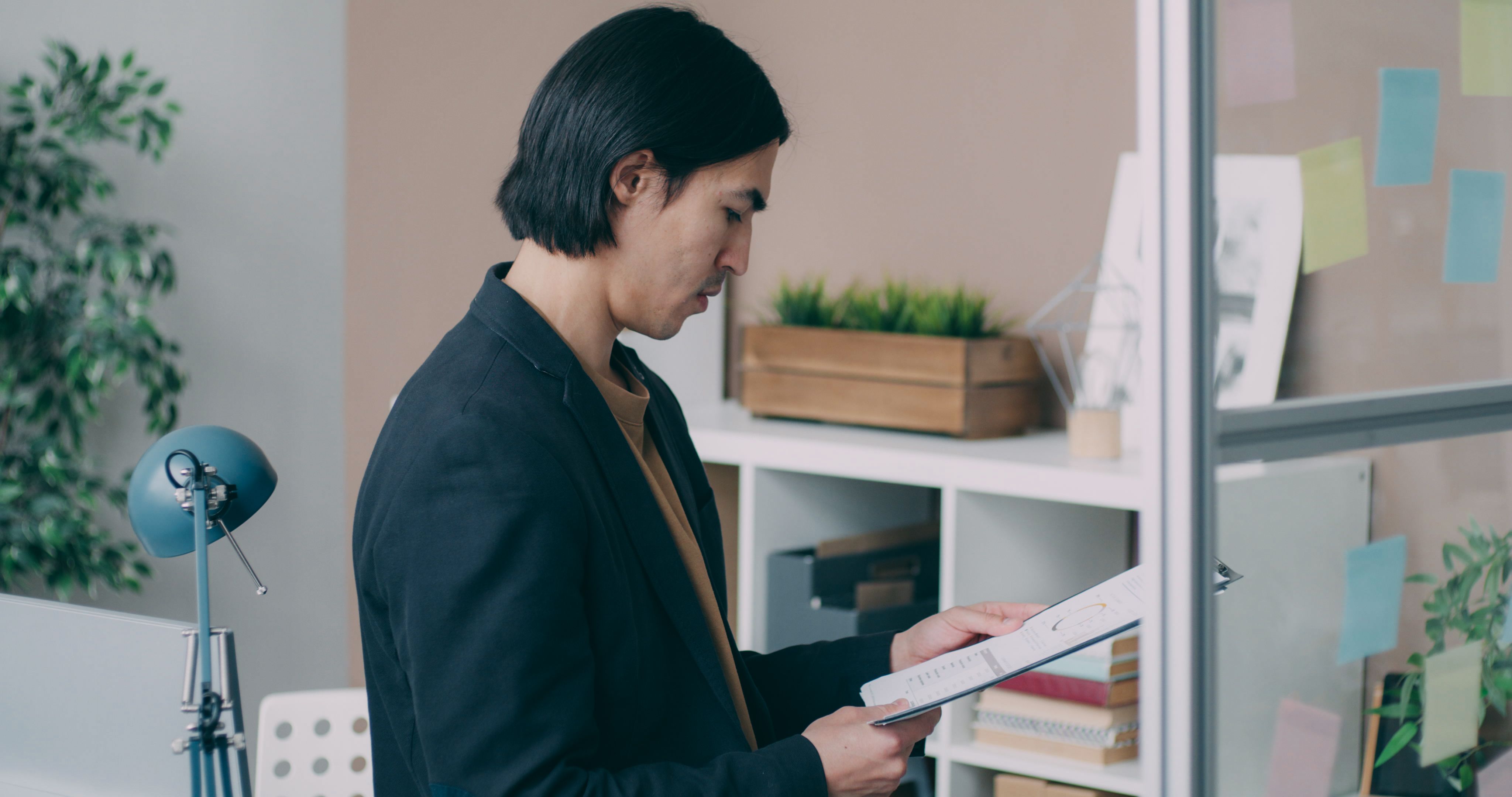 Young Professional Reviewing Documents in Office · Free Stock Photo