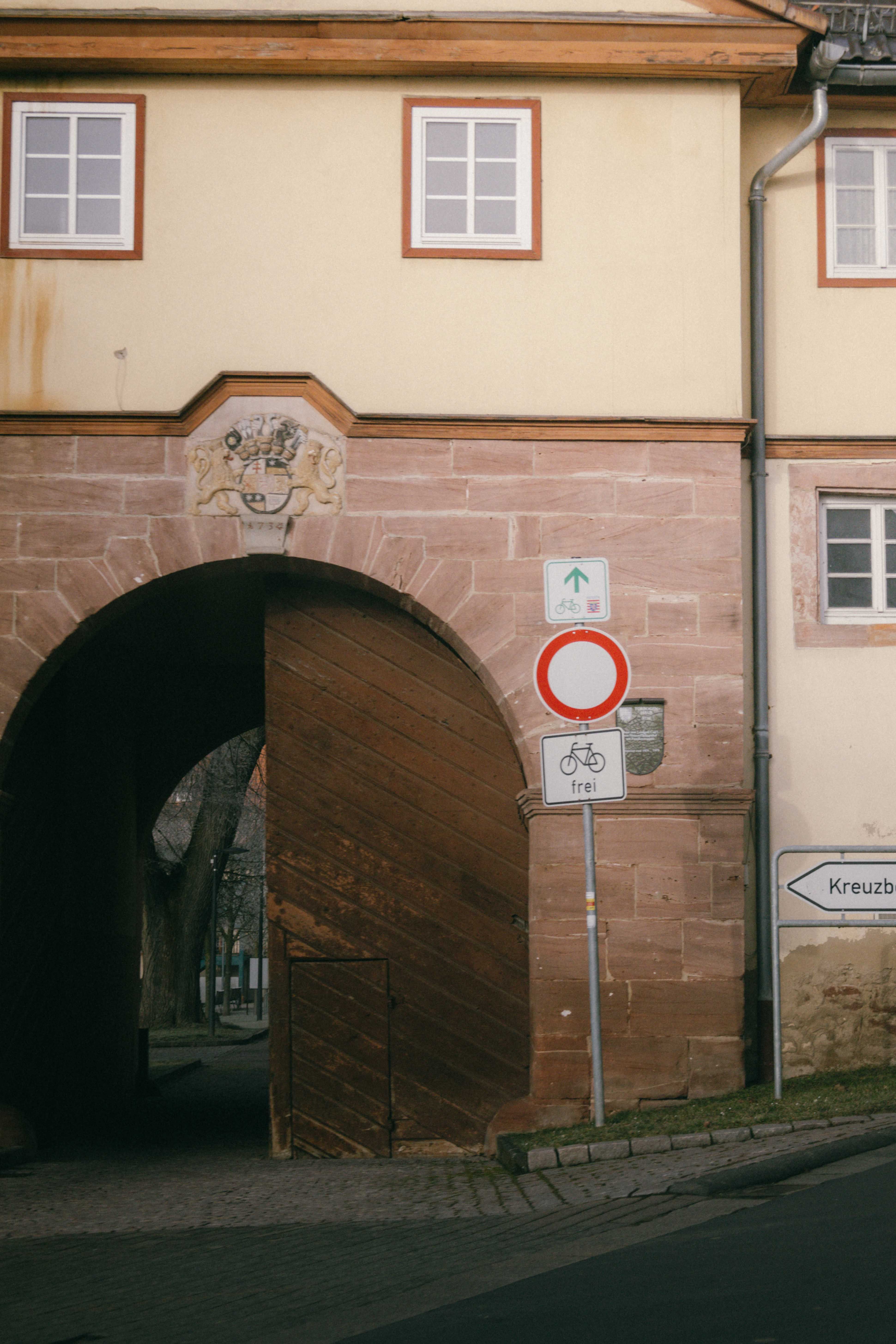 Historic Archway with Traffic Signs in European Town · Free Stock Photo