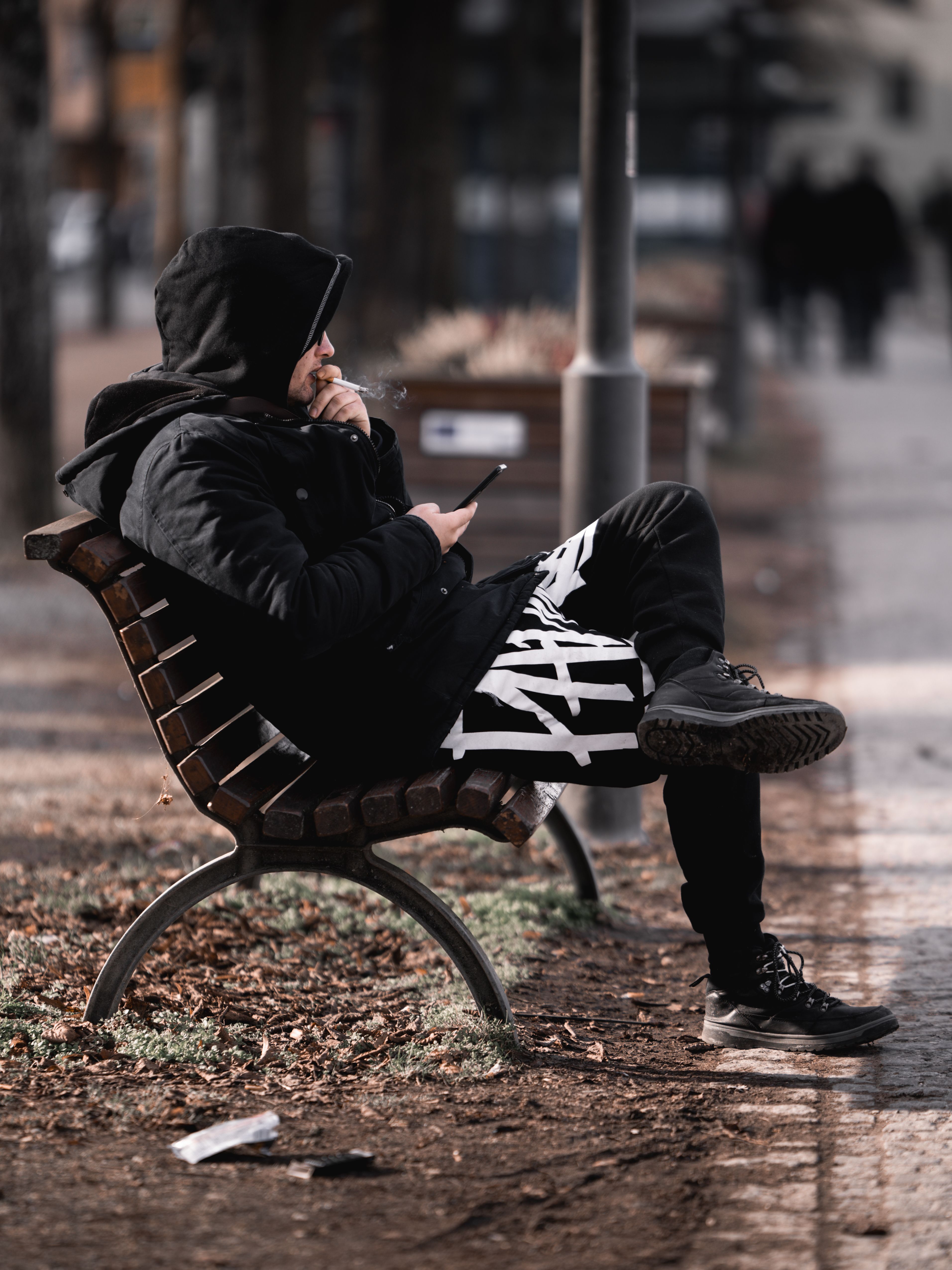 Urban Smoker Relaxing on a Park Bench · Free Stock Photo