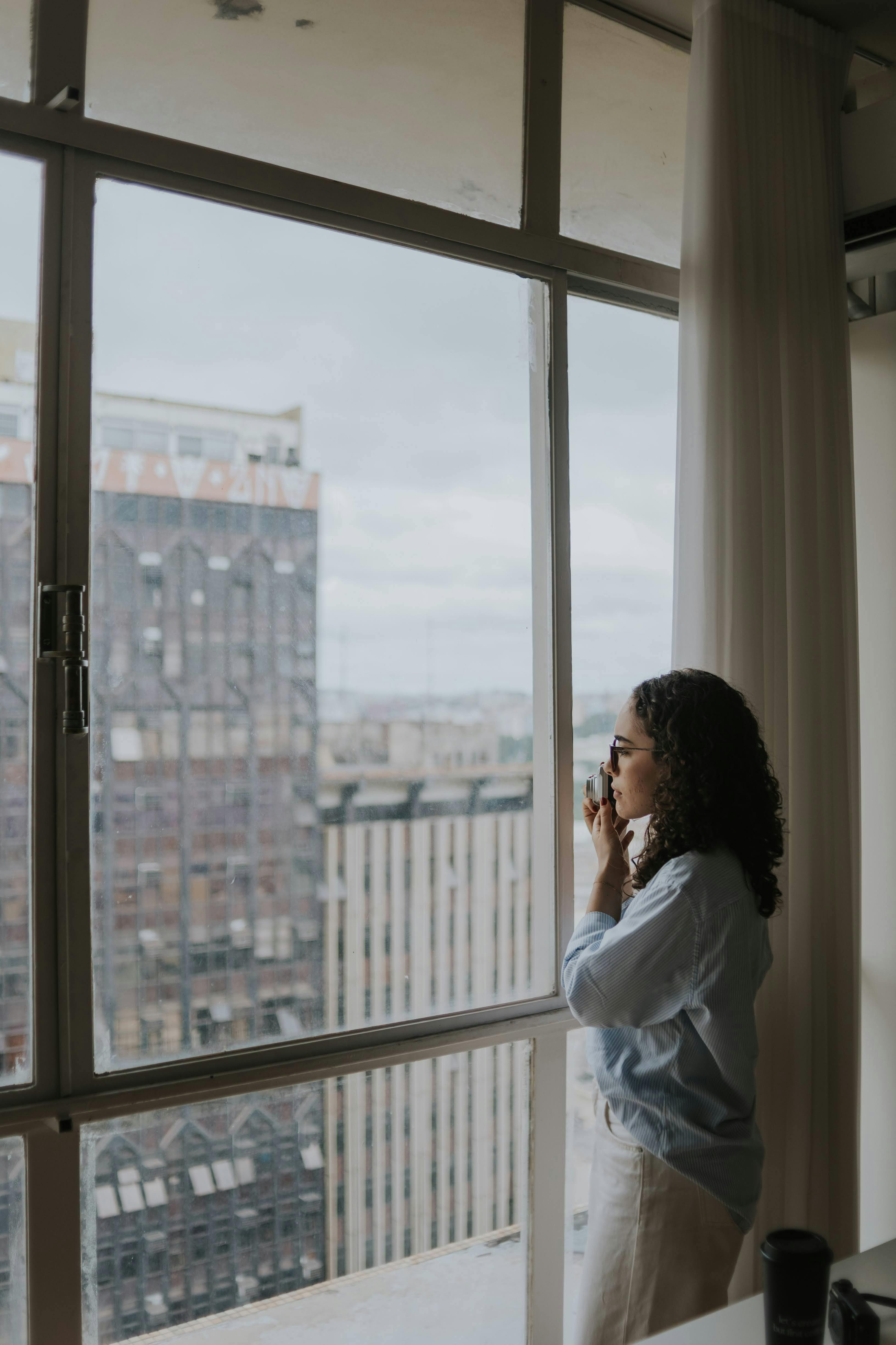 Woman Looking Out Urban Office Window · Free Stock Photo