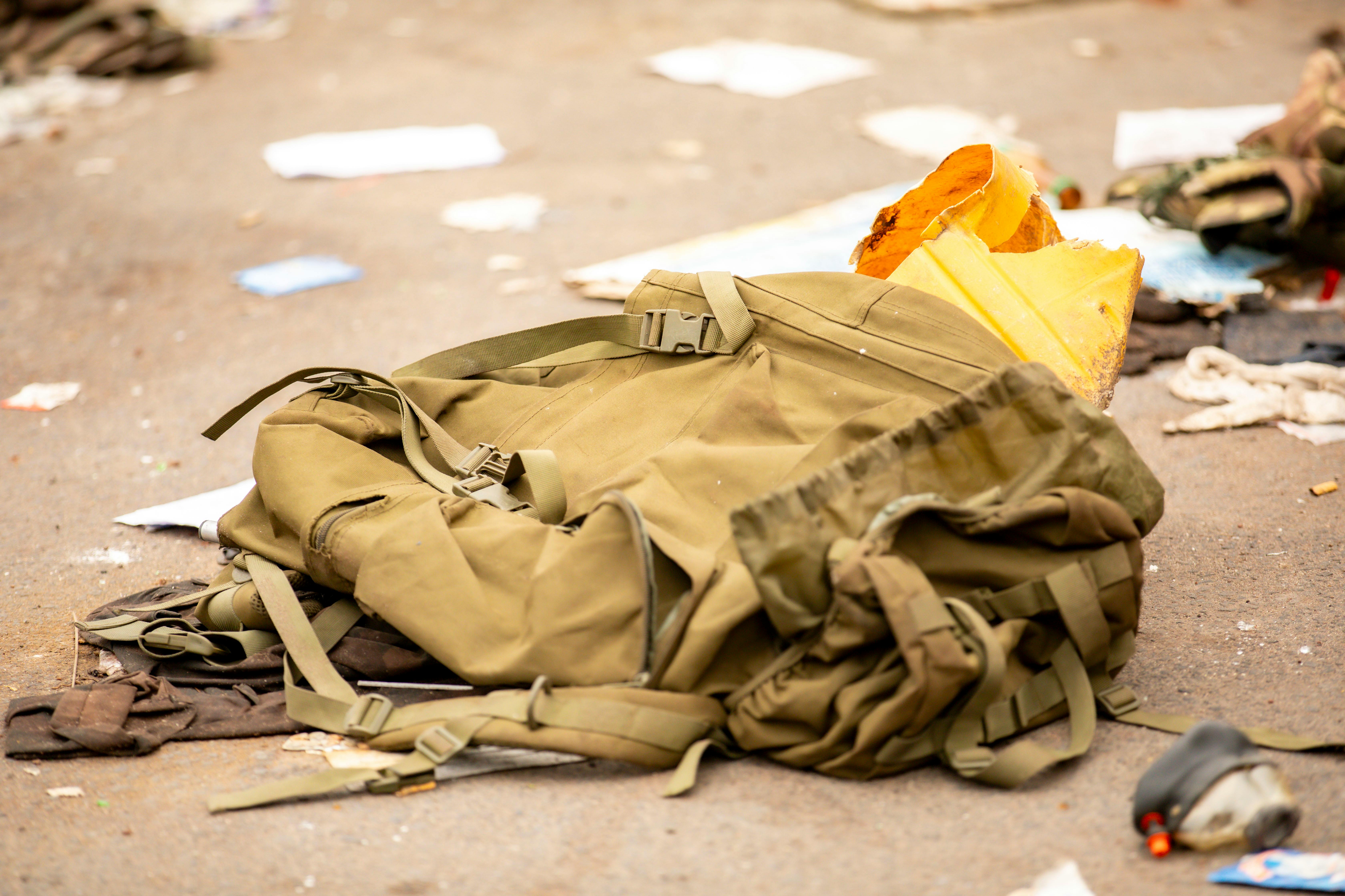 Military Backpack on Littered Urban Street · Free Stock Photo