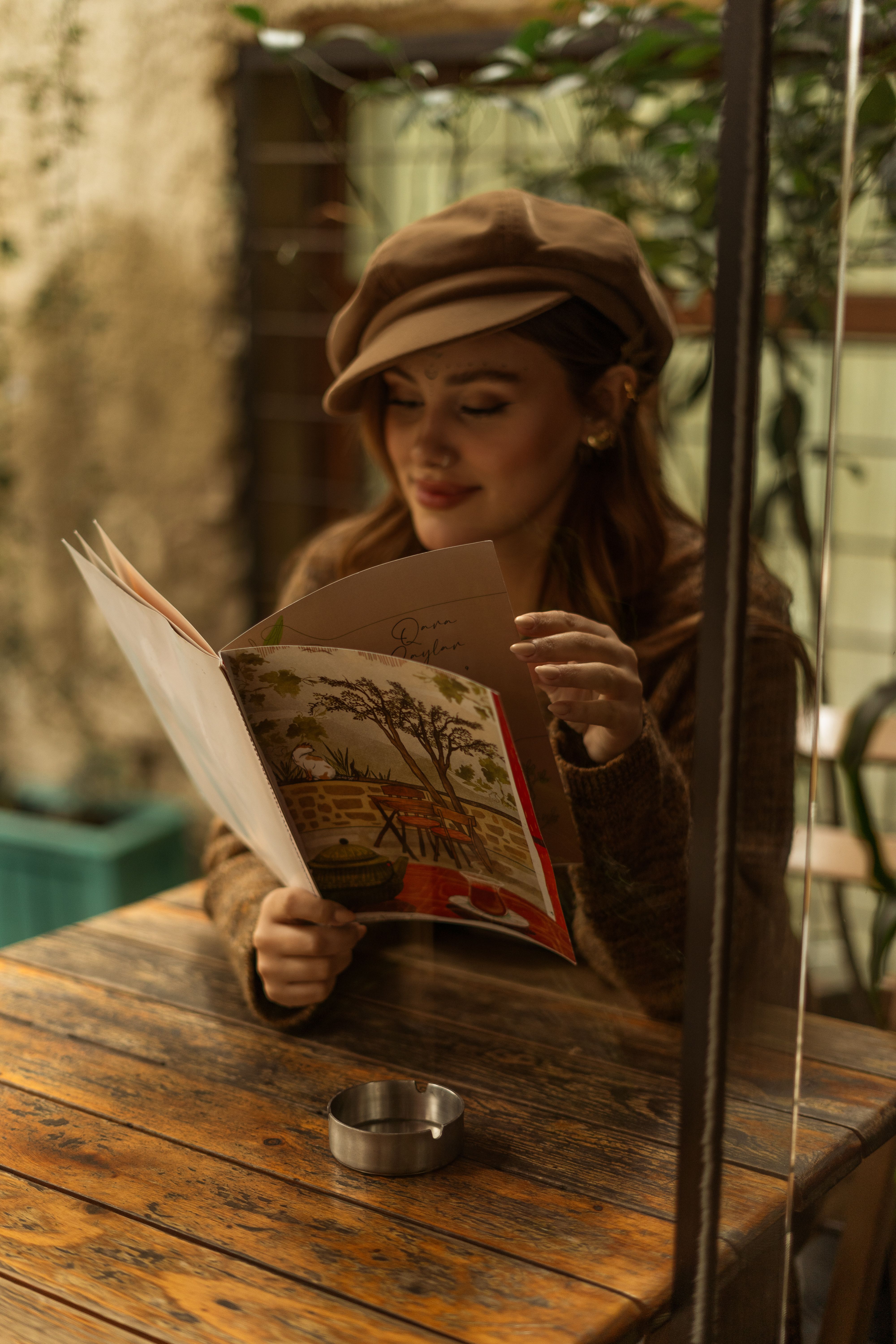 Woman Reading a Menu in a Cozy Cafe Setting · Free Stock Photo