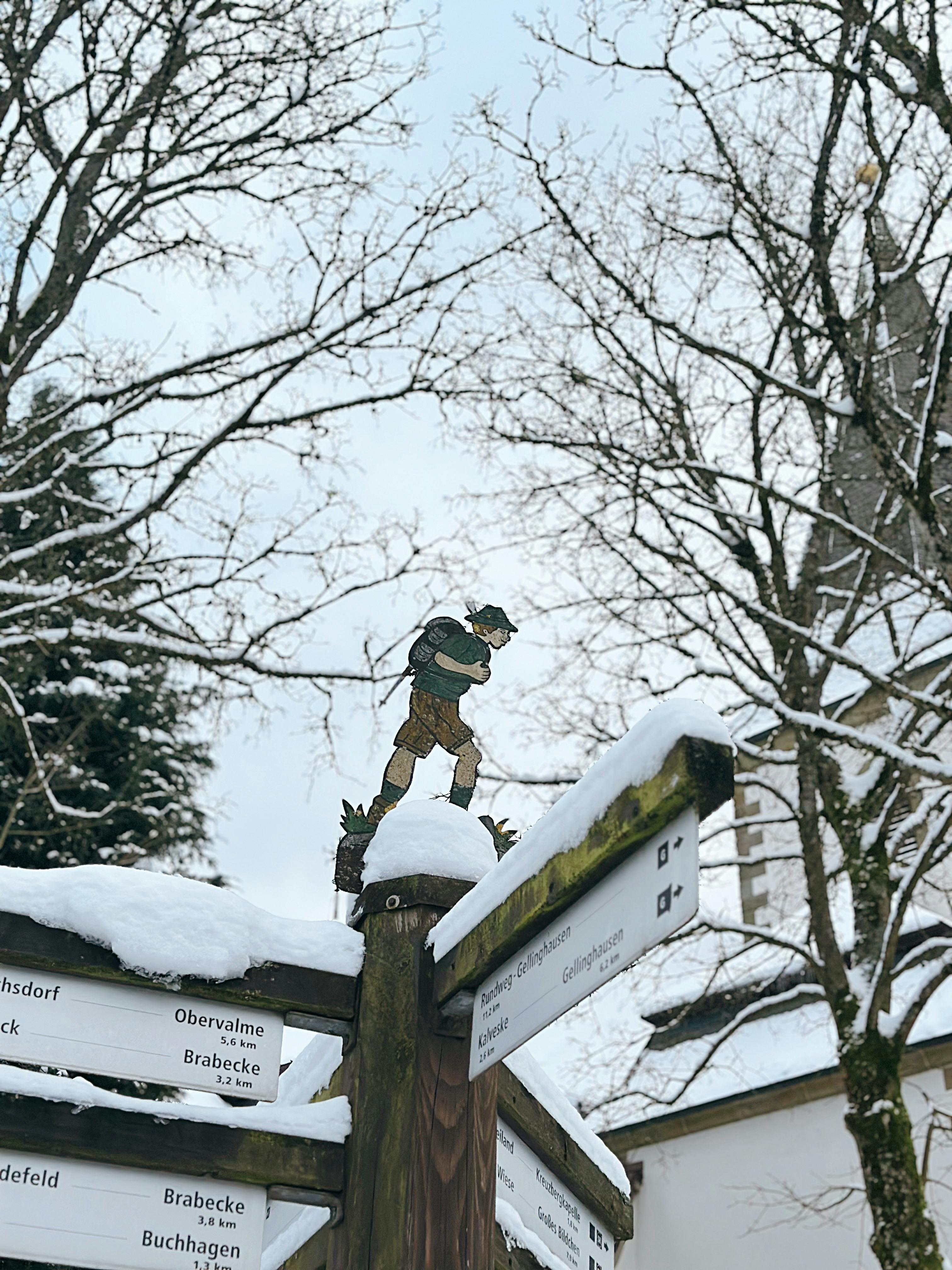 Snow-Covered Signpost with Forest and Church · Free Stock Photo