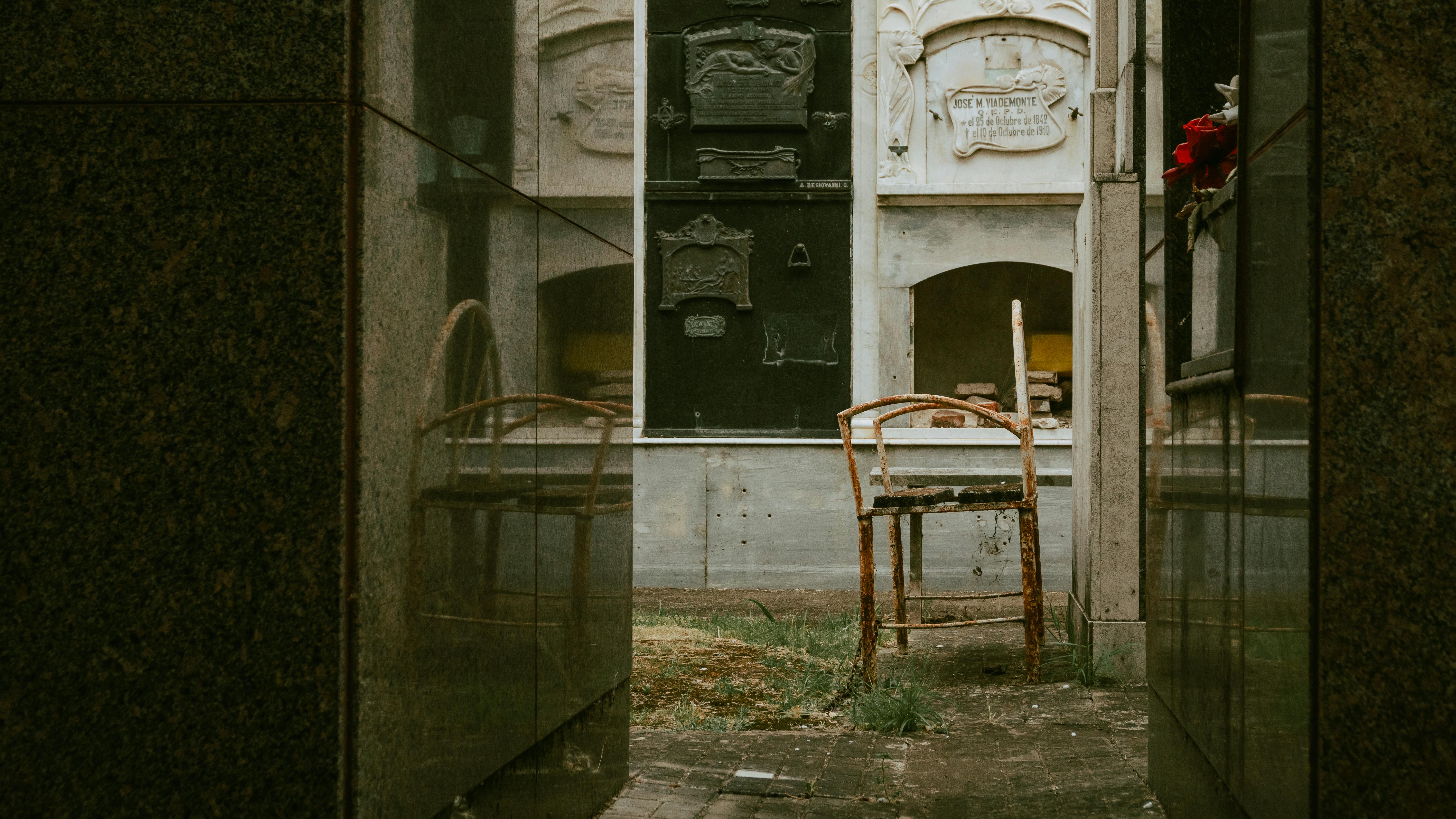 Cemetery Passage with Rusty Chair and Reflective Walls · Free Stock Photo