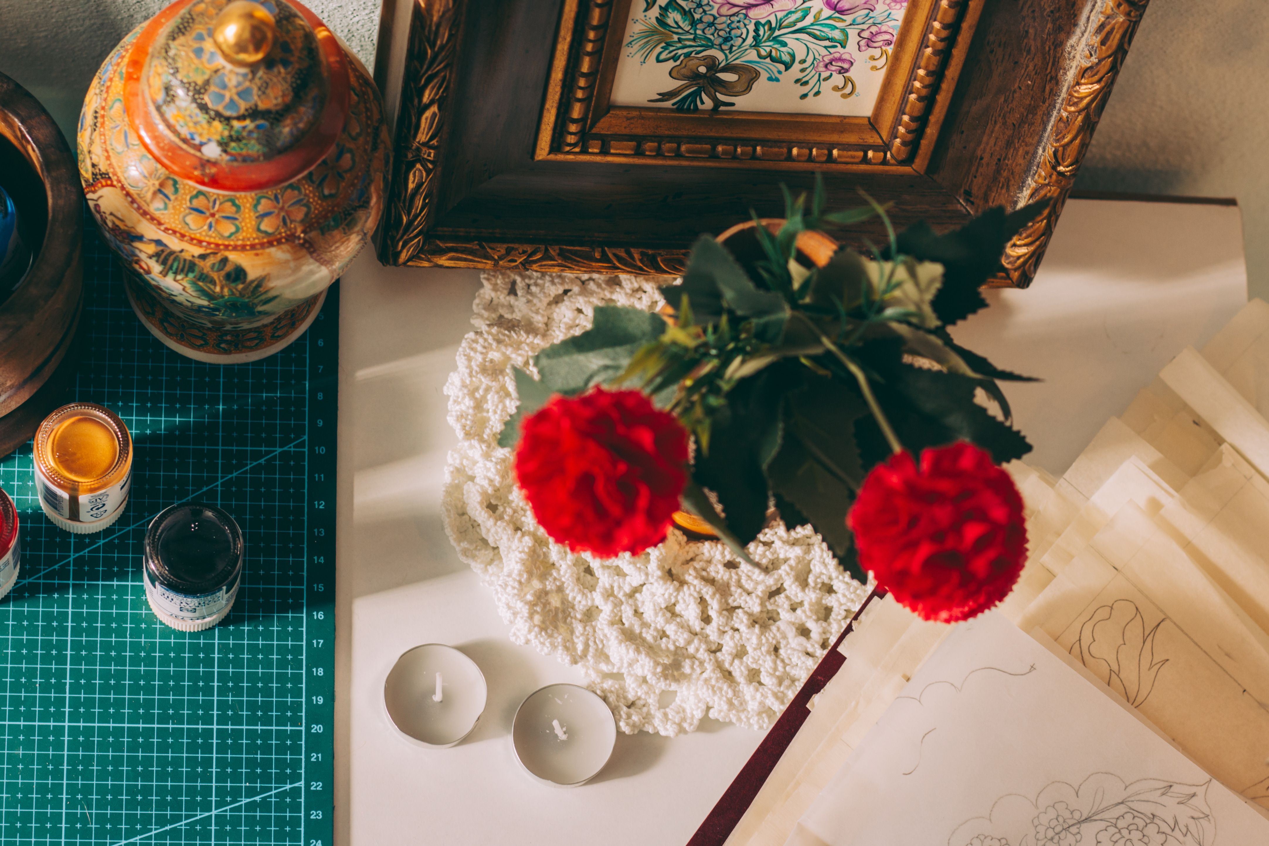 Artistic Desk Setup with Red Carnations and Painting · Free Stock Photo