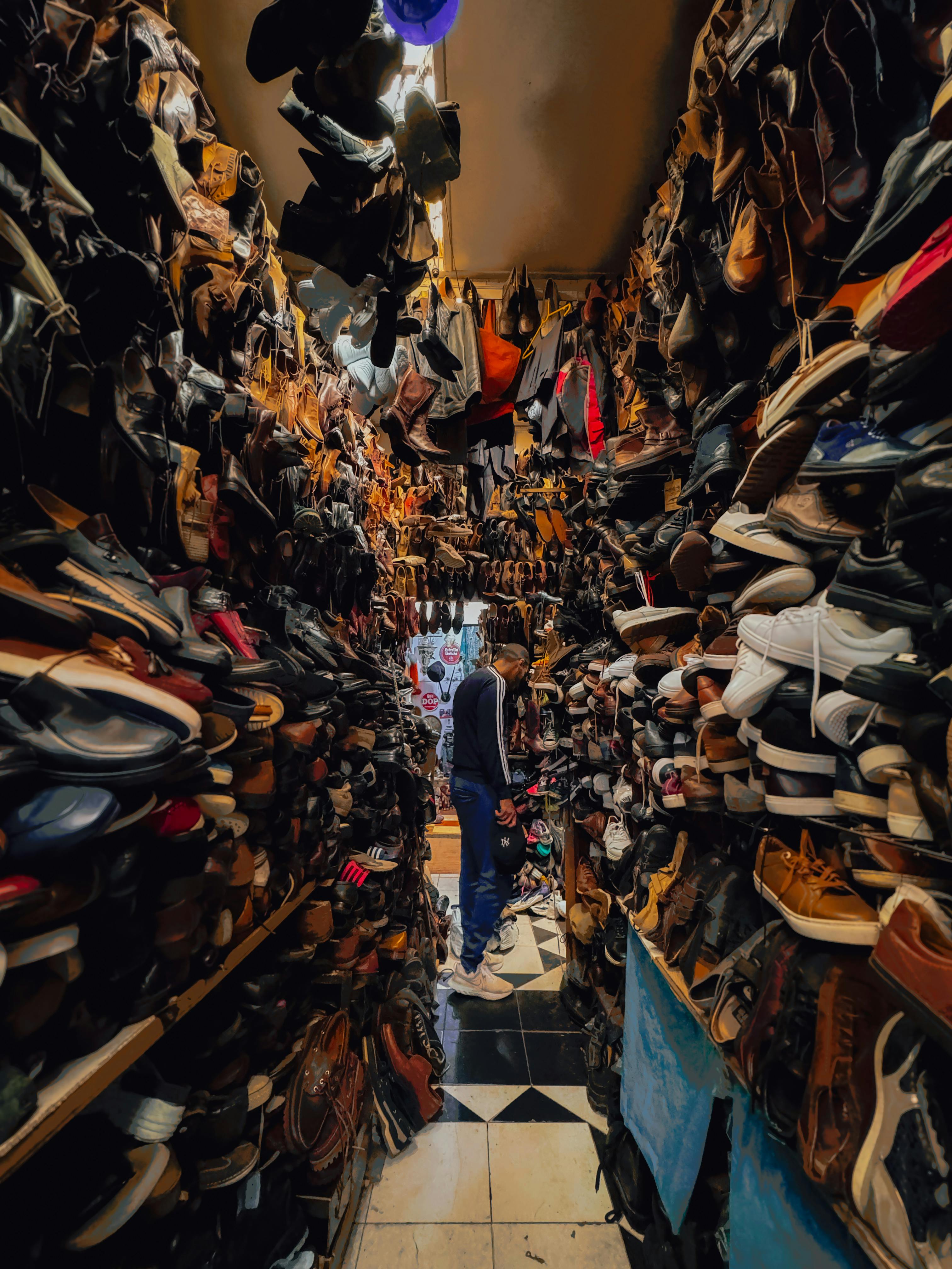 Crowded Vintage Shoe Store with Shopper Inside · Free Stock Photo