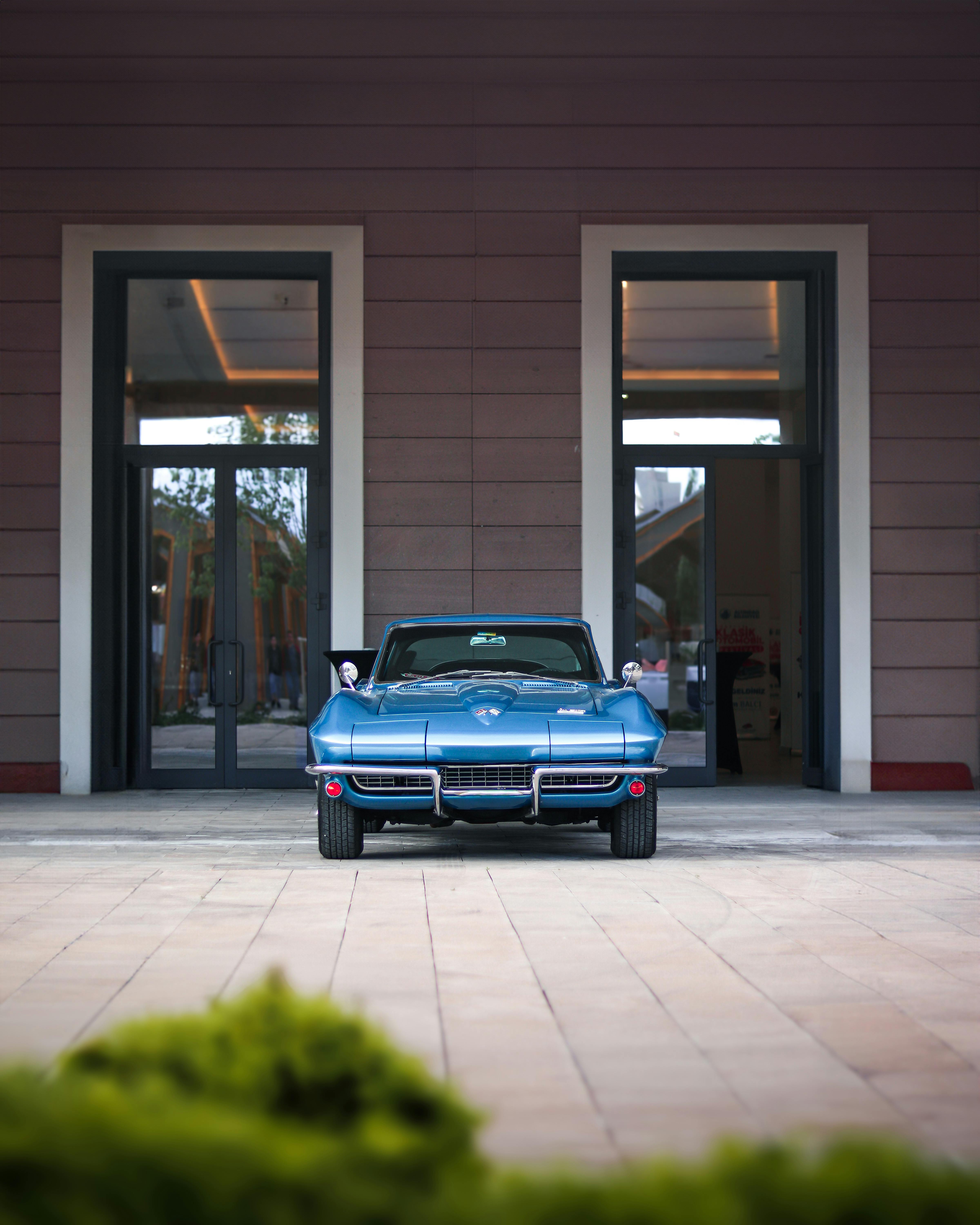Classic Blue Car Framed by Modern Architecture · Free Stock Photo