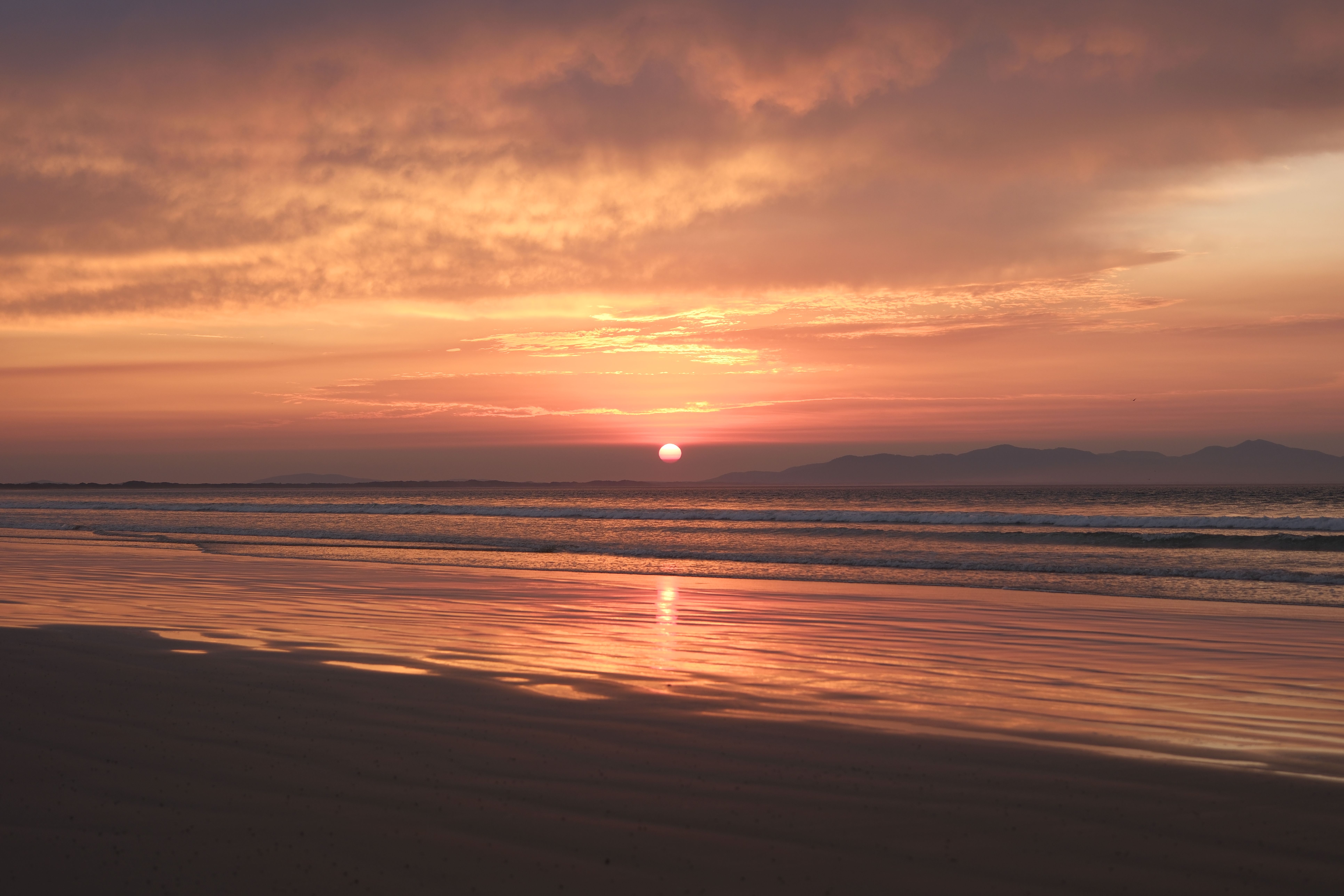 Serene Beach Sunset Over Calm Ocean Waves · Free Stock Photo