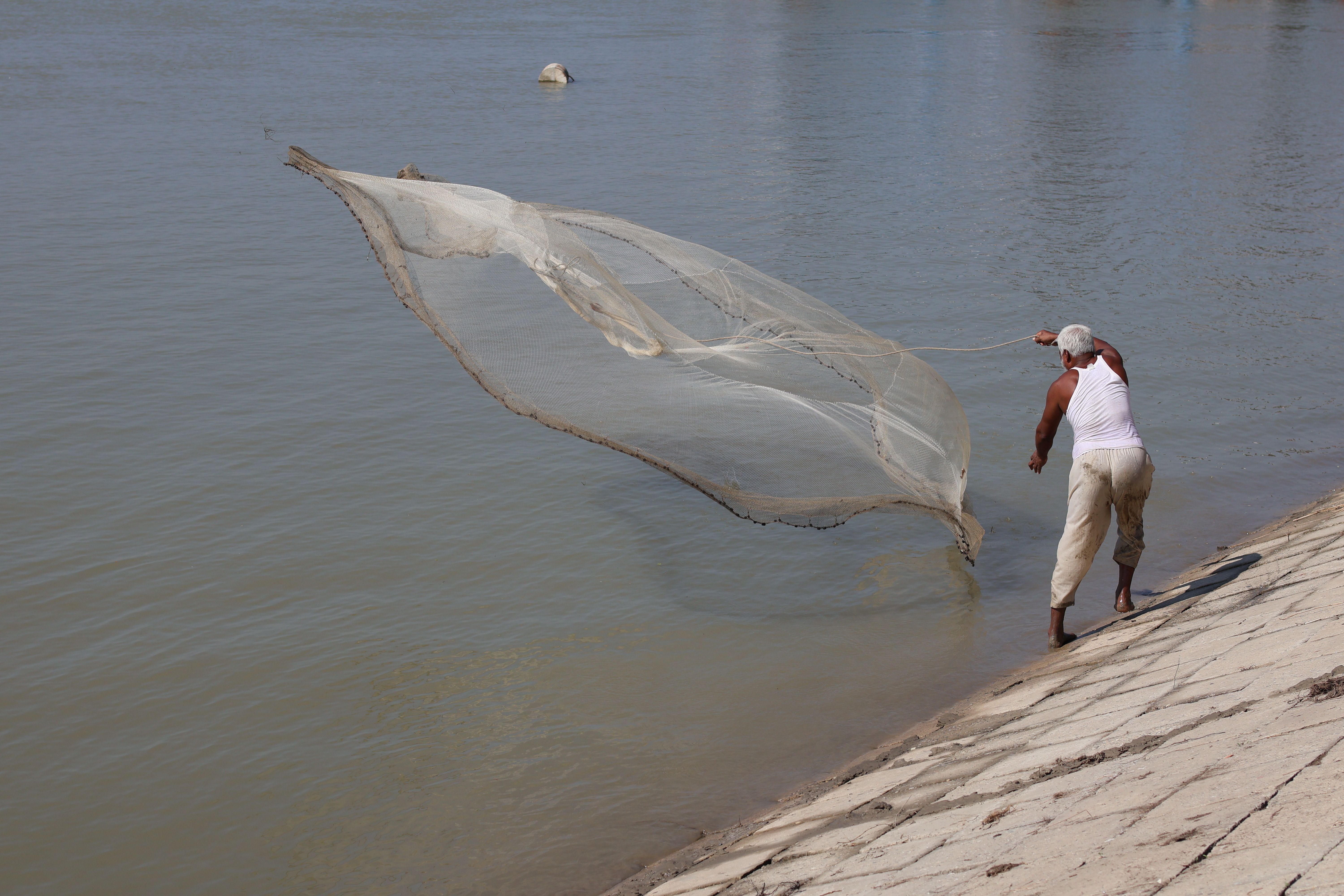 Pescador Lanzando Red Junto Al Río En Pabna · Foto de stock gratuita