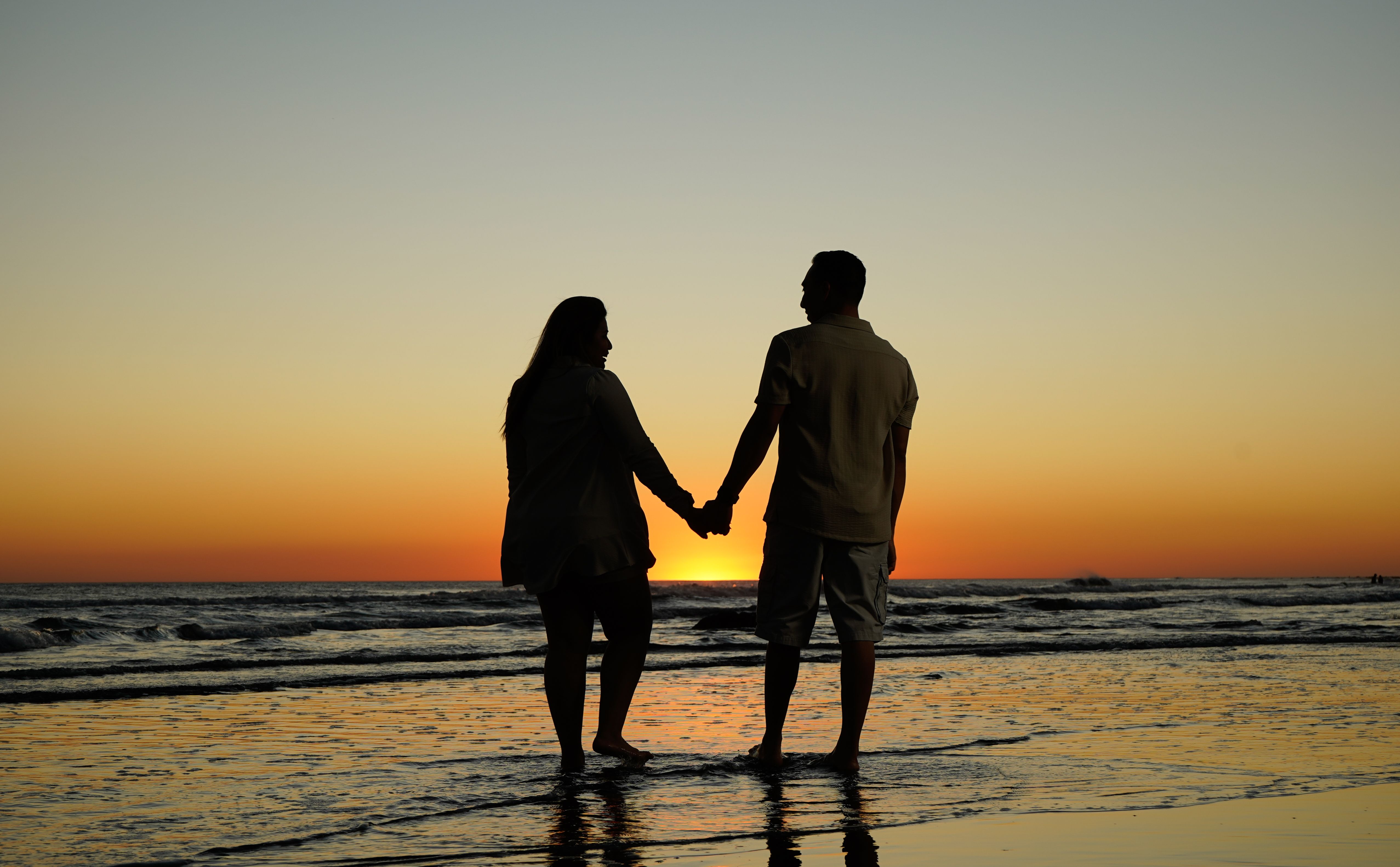 Couple Romantique Se Tenant La Main Sur La Plage Au Coucher Du Soleil ...