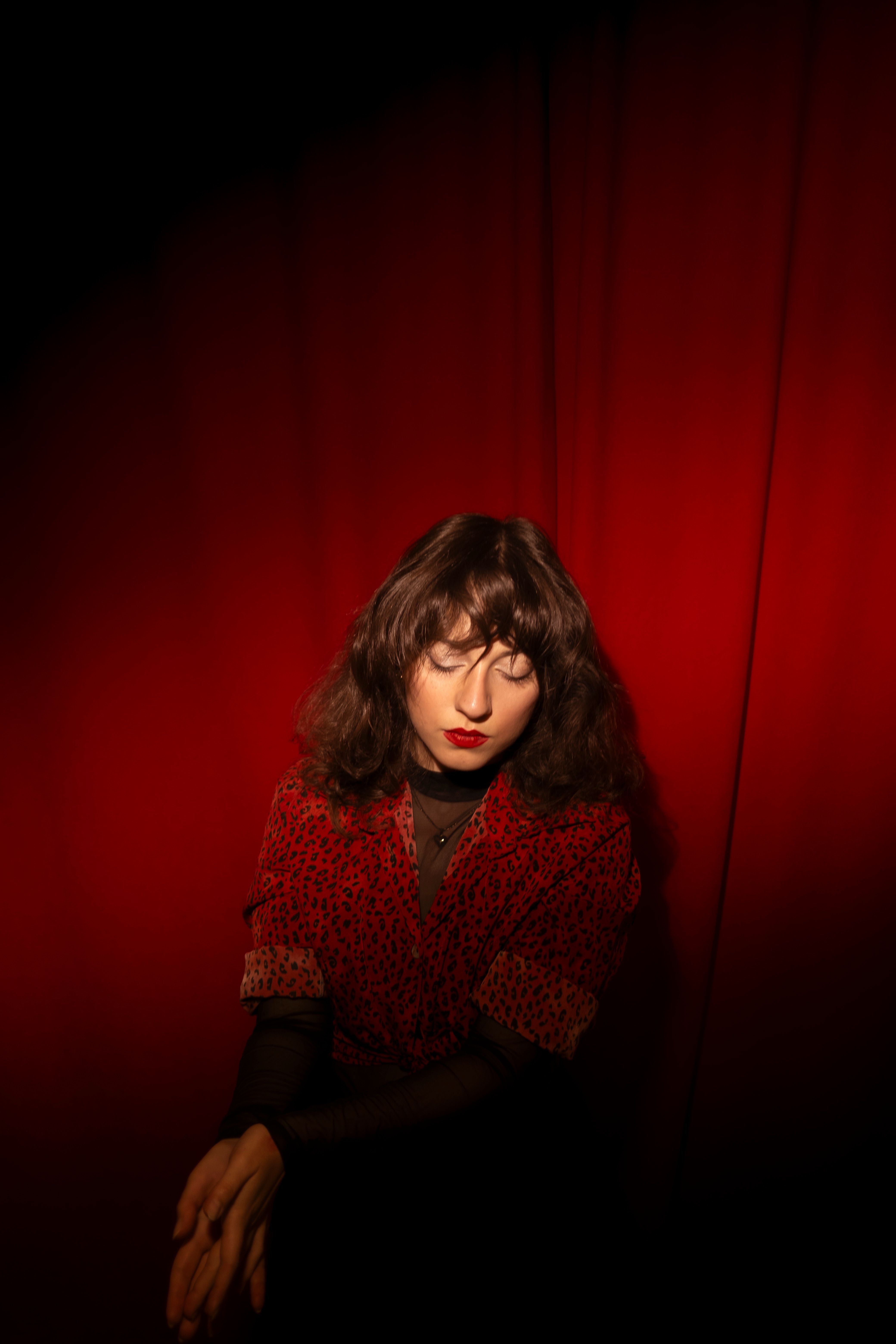 Artistic Portrait Against Vibrant Red Curtain · Free Stock Photo
