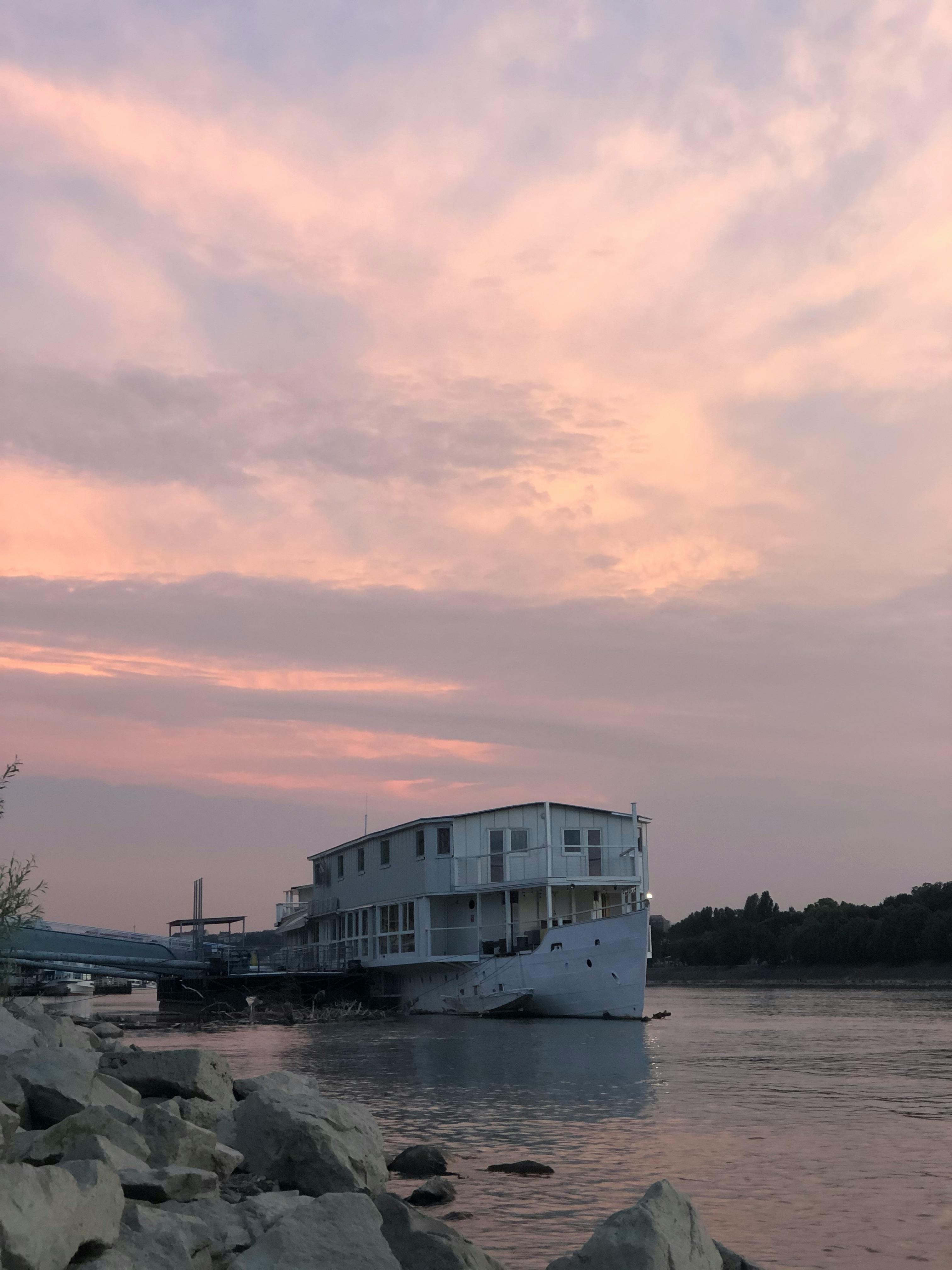 Serene Riverboat at Sunset with Pink Skies · Free Stock Photo