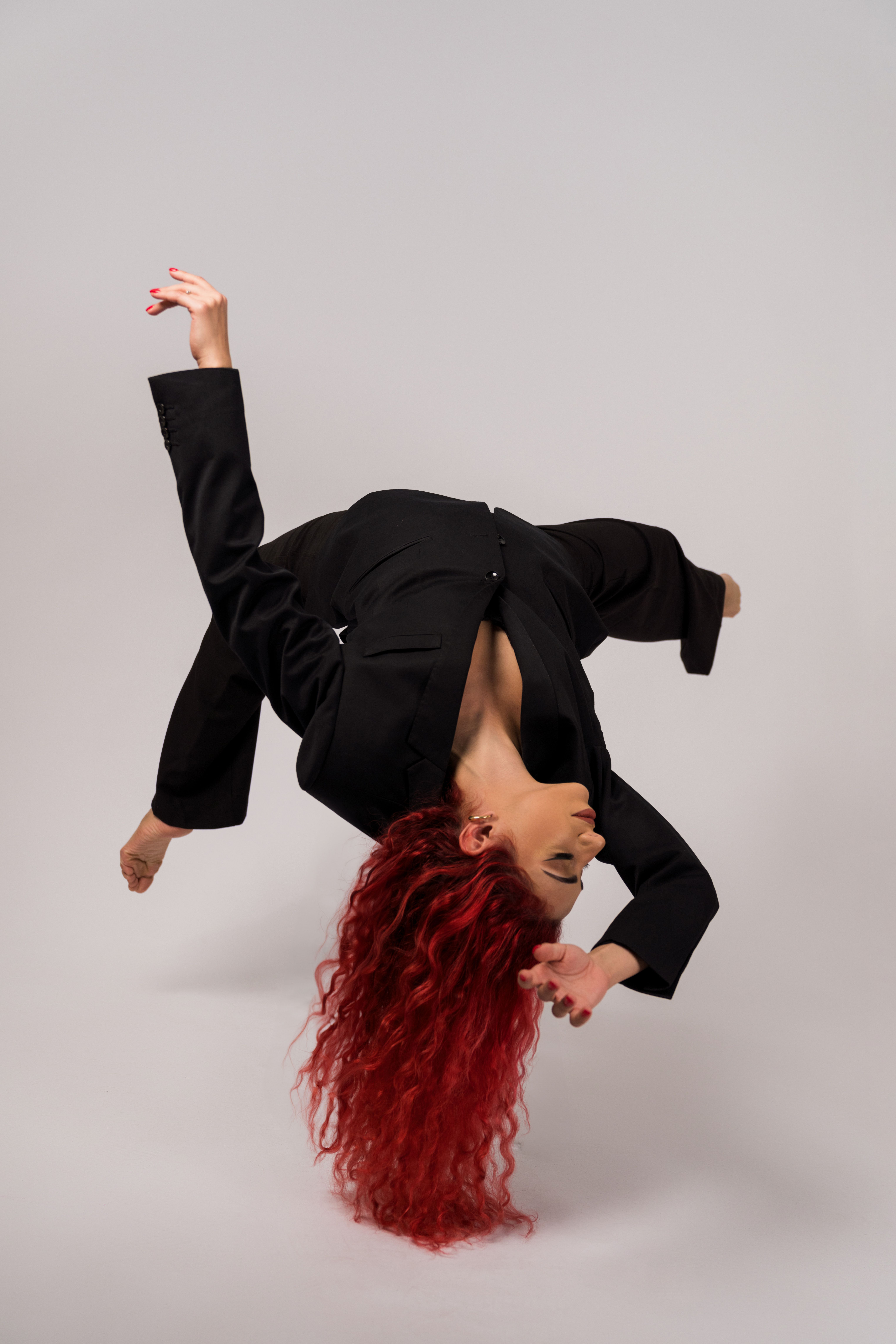 Dynamic Dance Pose with Red Hair and Black Suit · Free Stock Photo