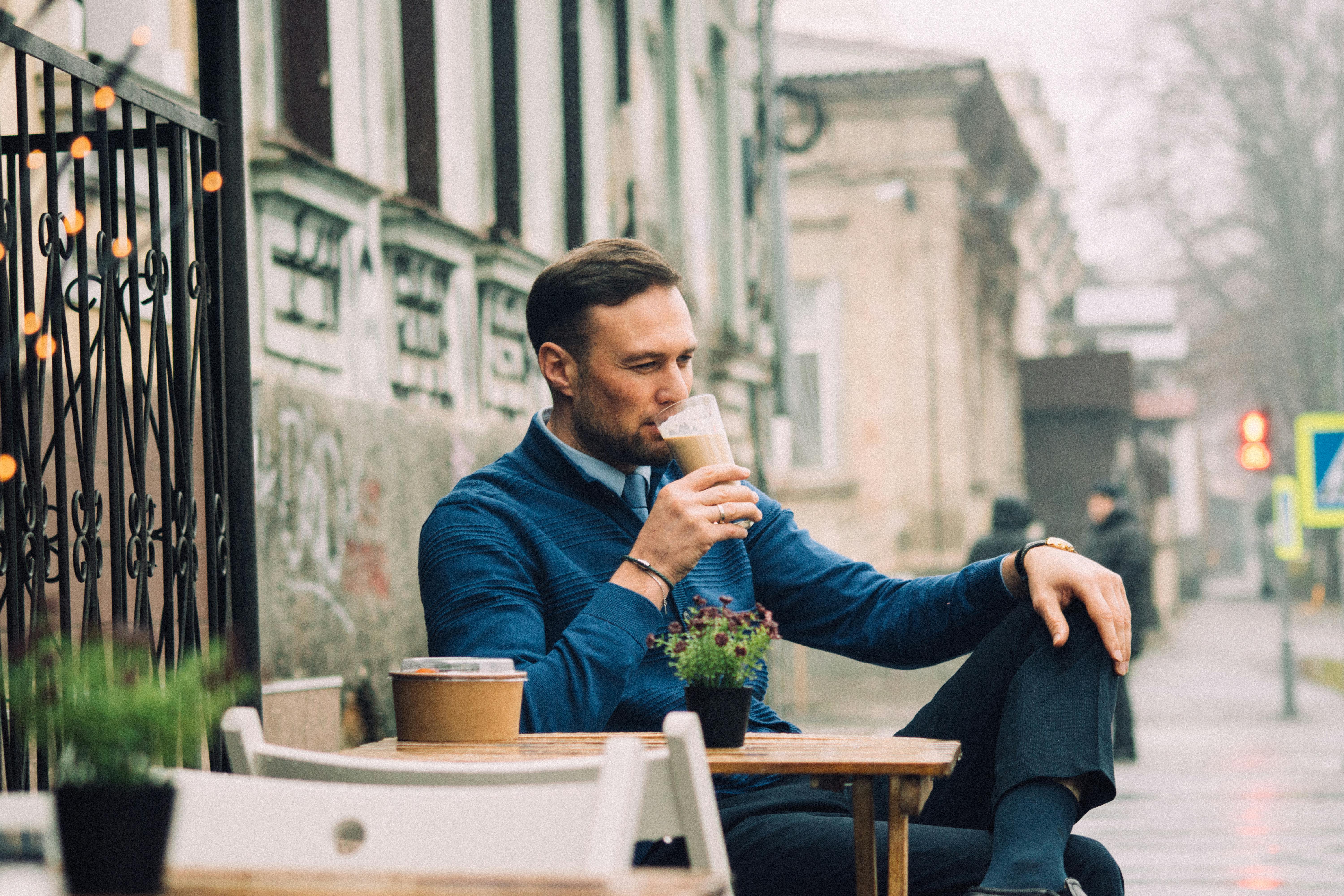 Young Man Enjoying Coffee at Outdoor Cafe · Free Stock Photo
