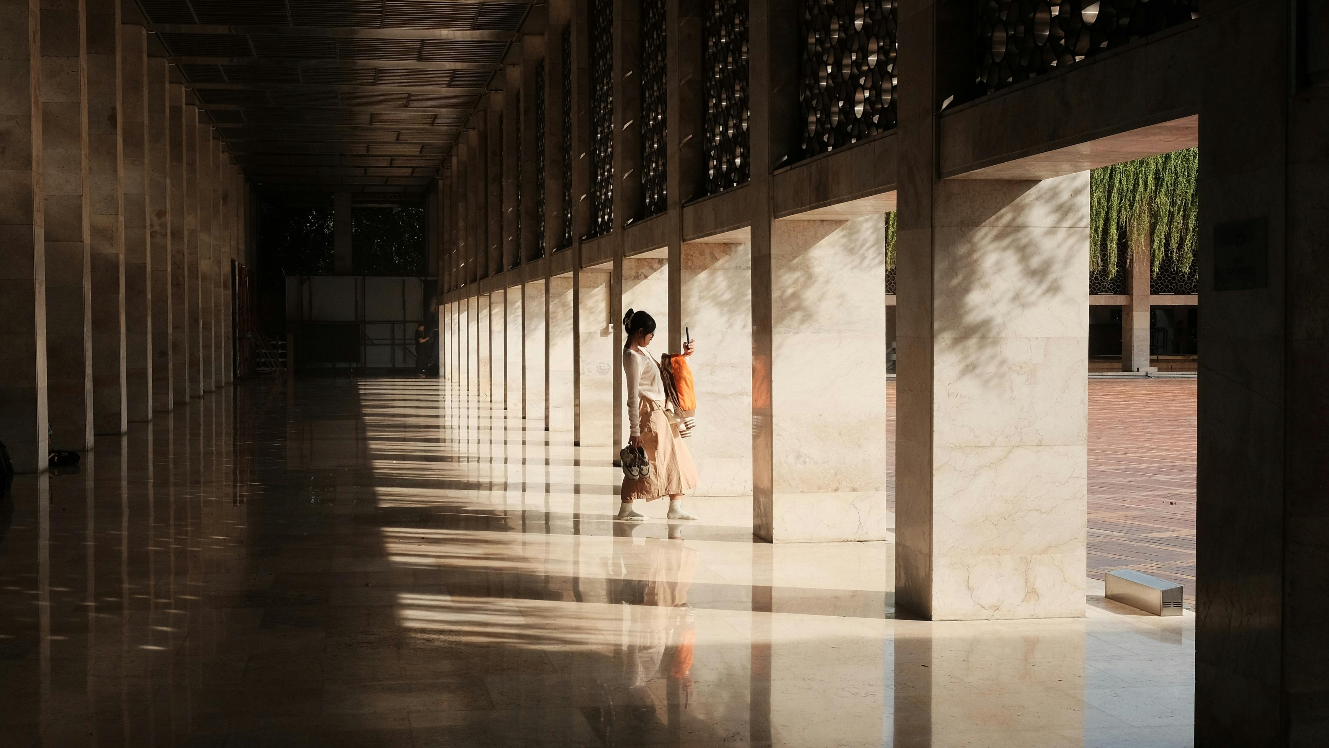 Sunlit Corridor with Woman Walking · Free Stock Photo