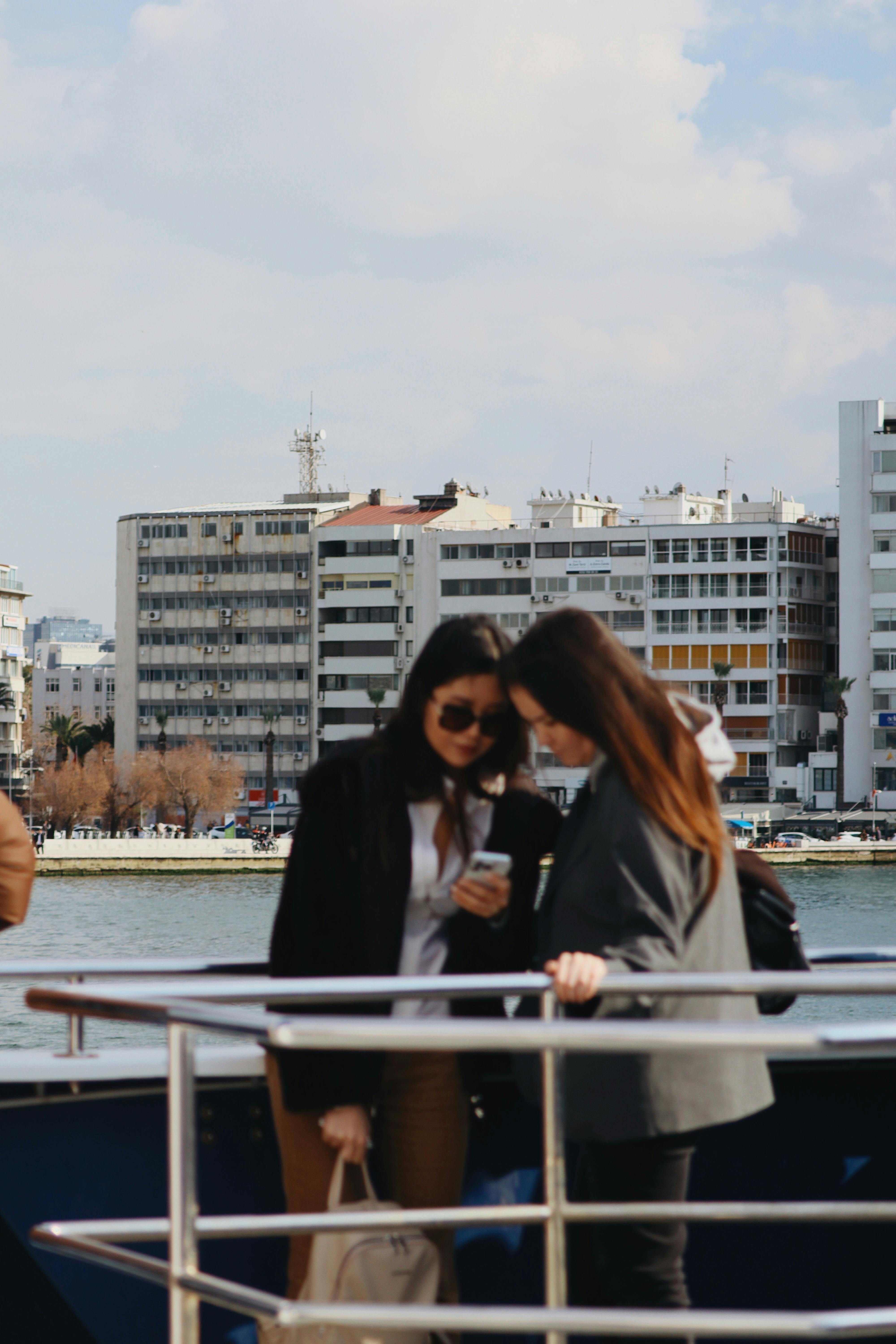 Two Women Checking Phone on İzmir Boat Ride · Free Stock Photo