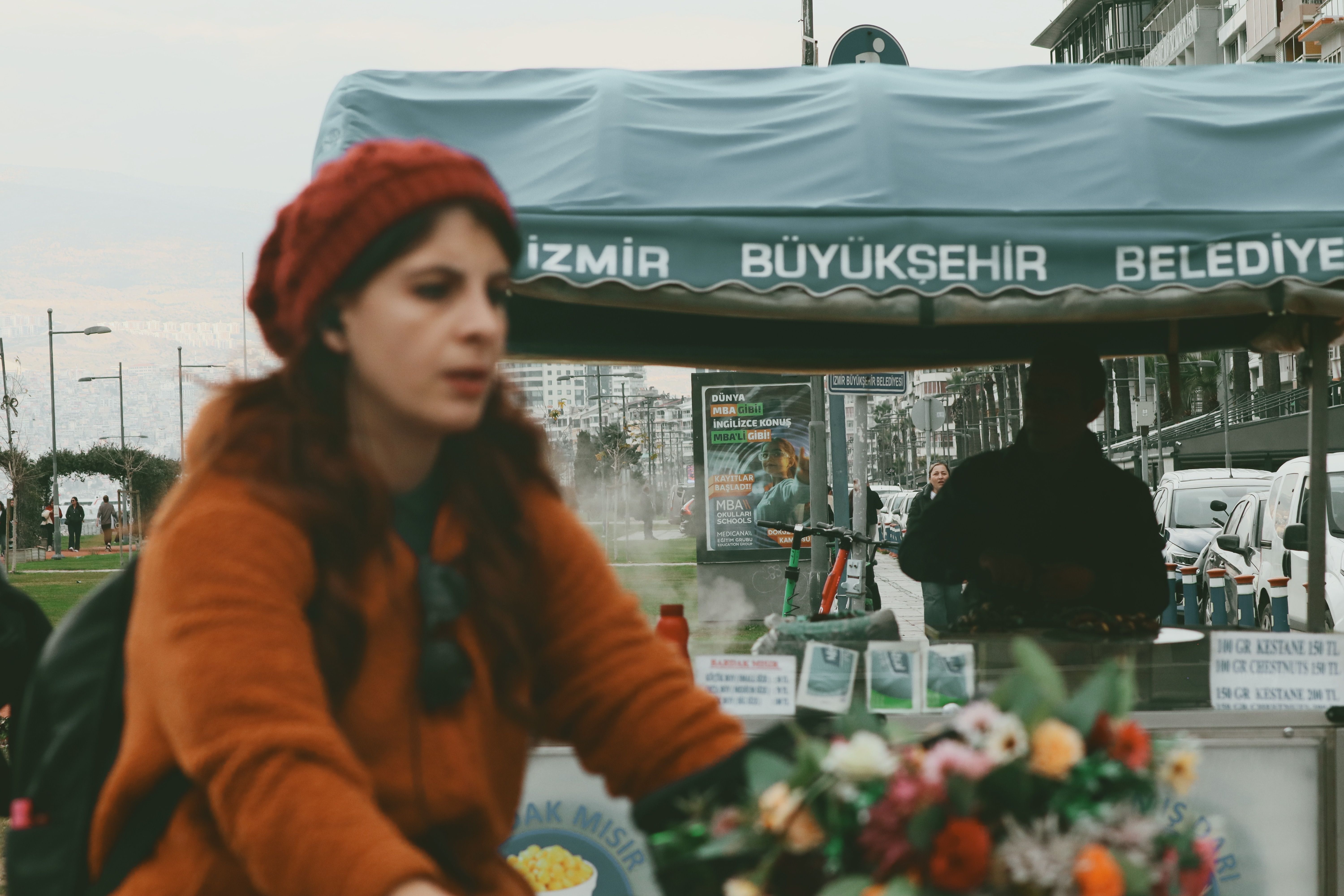 Woman Cycling Past Izmir Street Vendor · Free Stock Photo