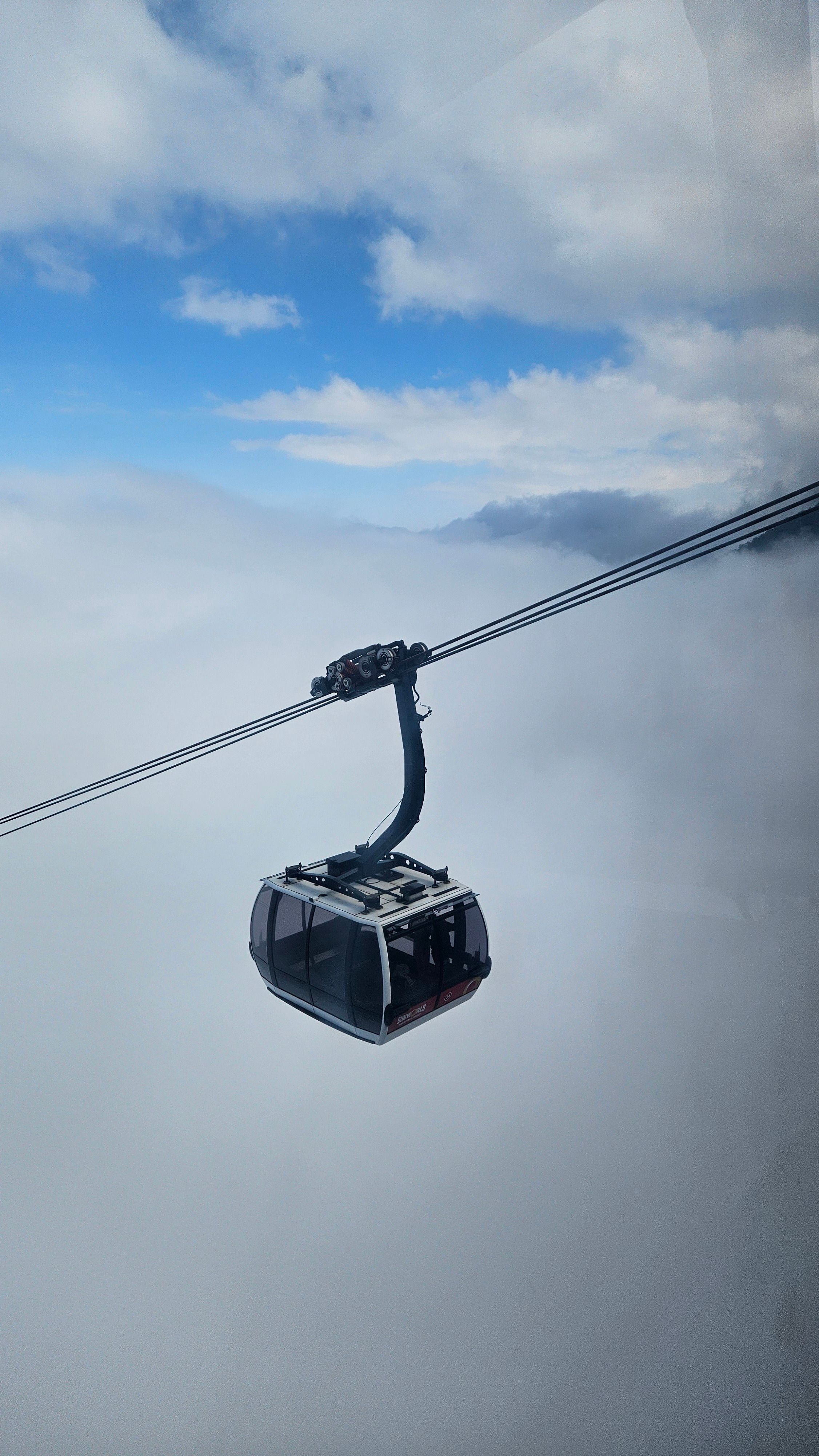 High-altitude cable car above clouds · Free Stock Photo