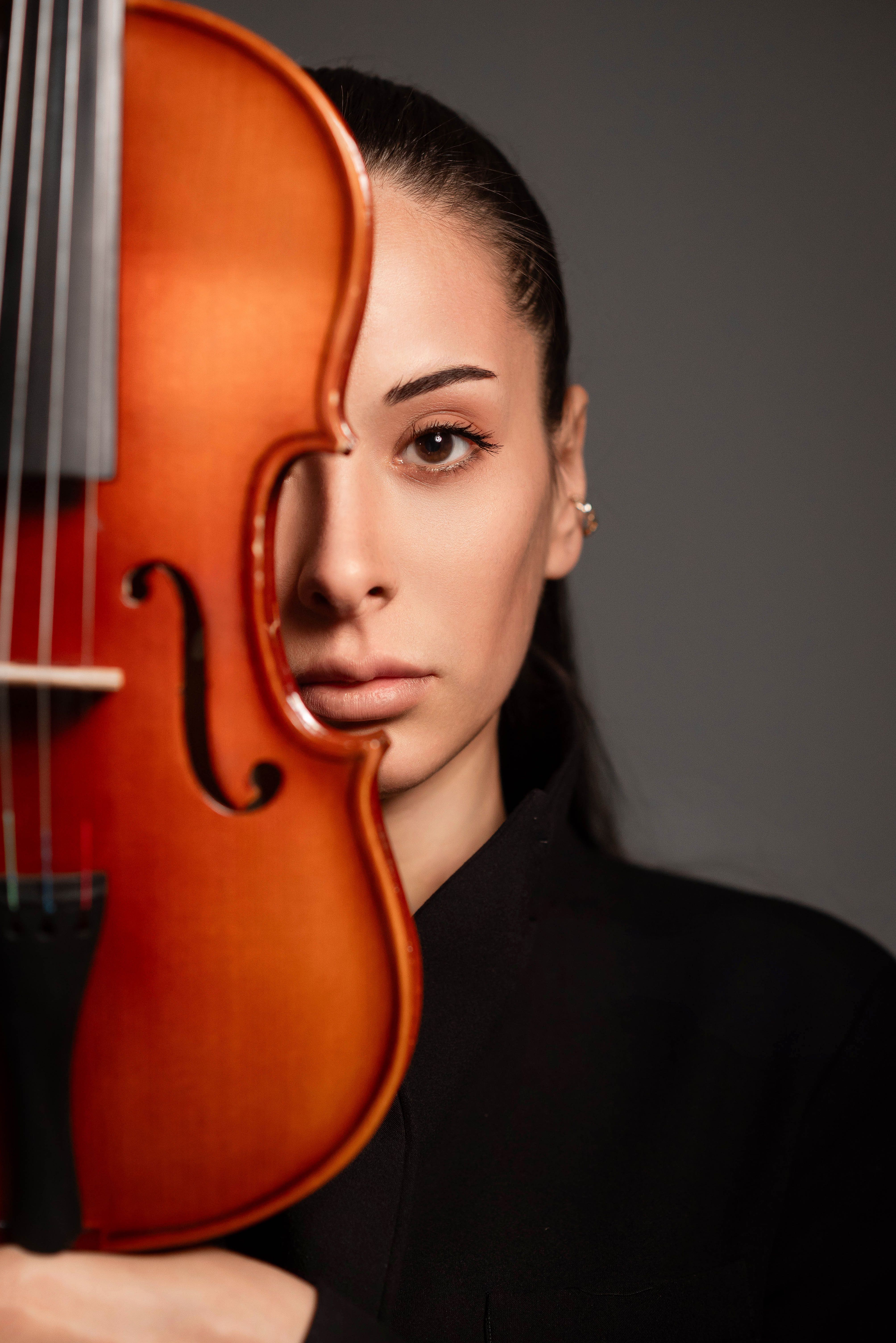Back View of a Woman in Black Dress Playing a Violin · Free Stock Photo