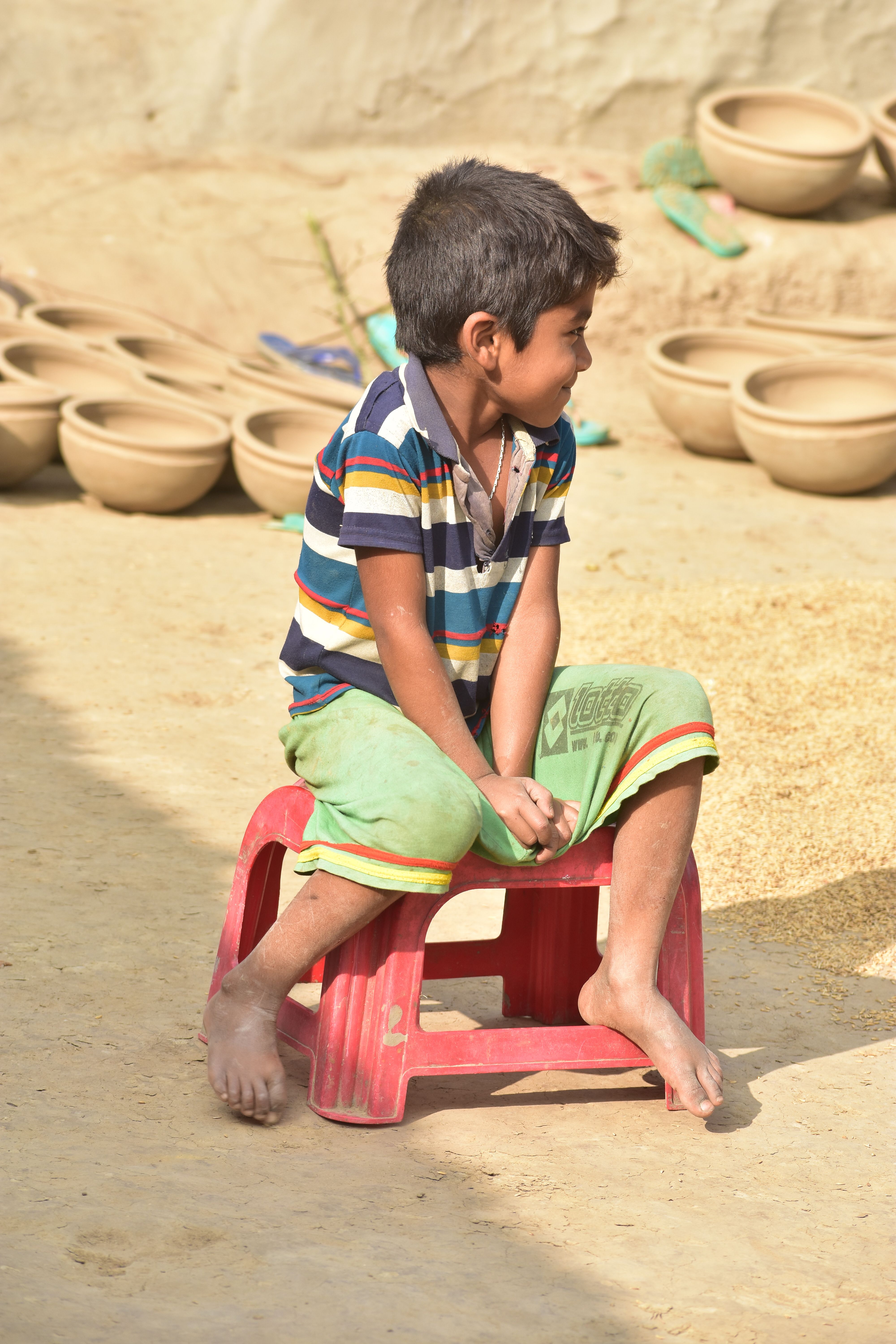 Young Boy Sitting Among Handmade Clay Pots · Free Stock Photo