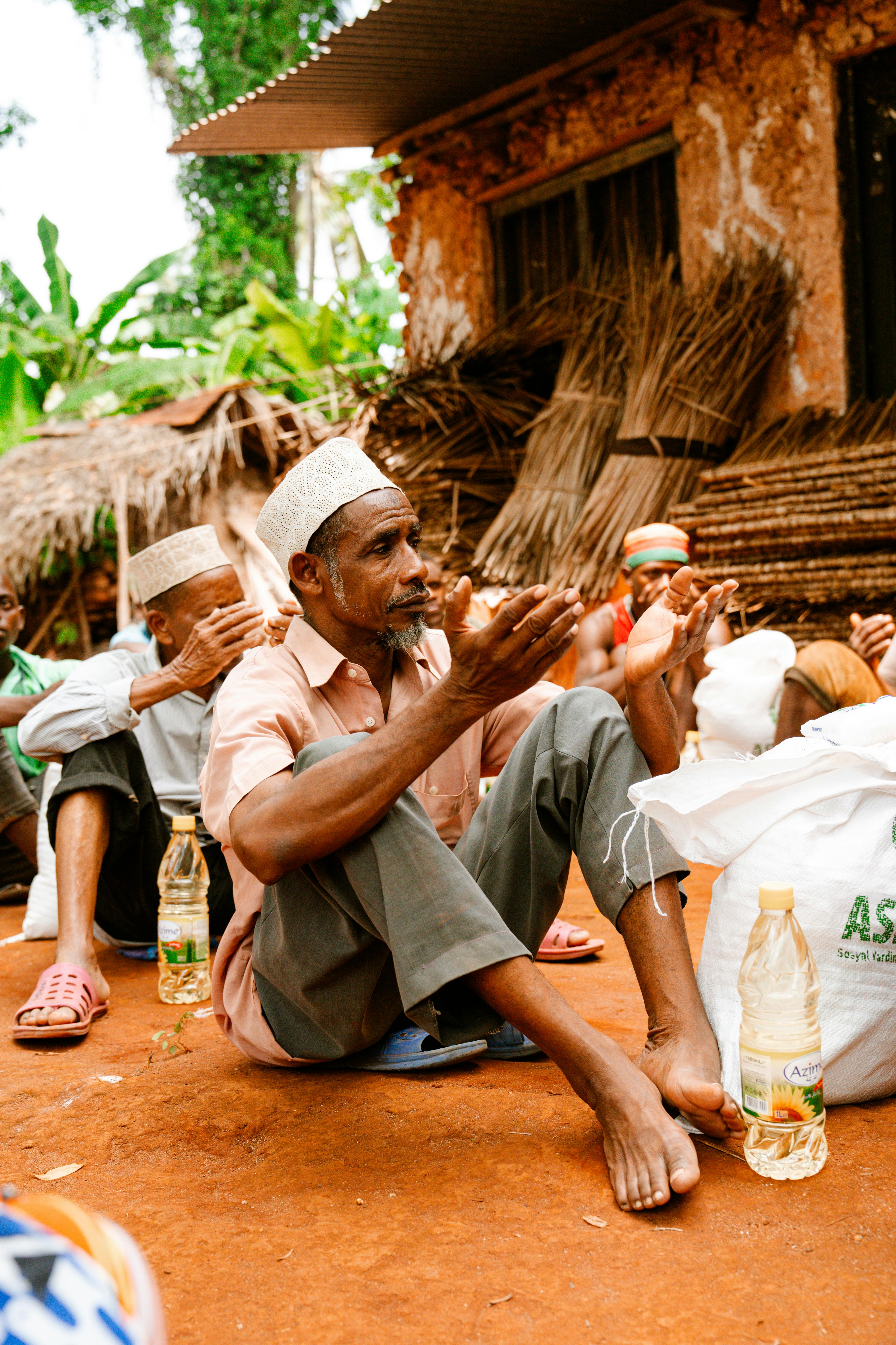 Group of Men Praying Outdoors in Rural Village · Free Stock Photo