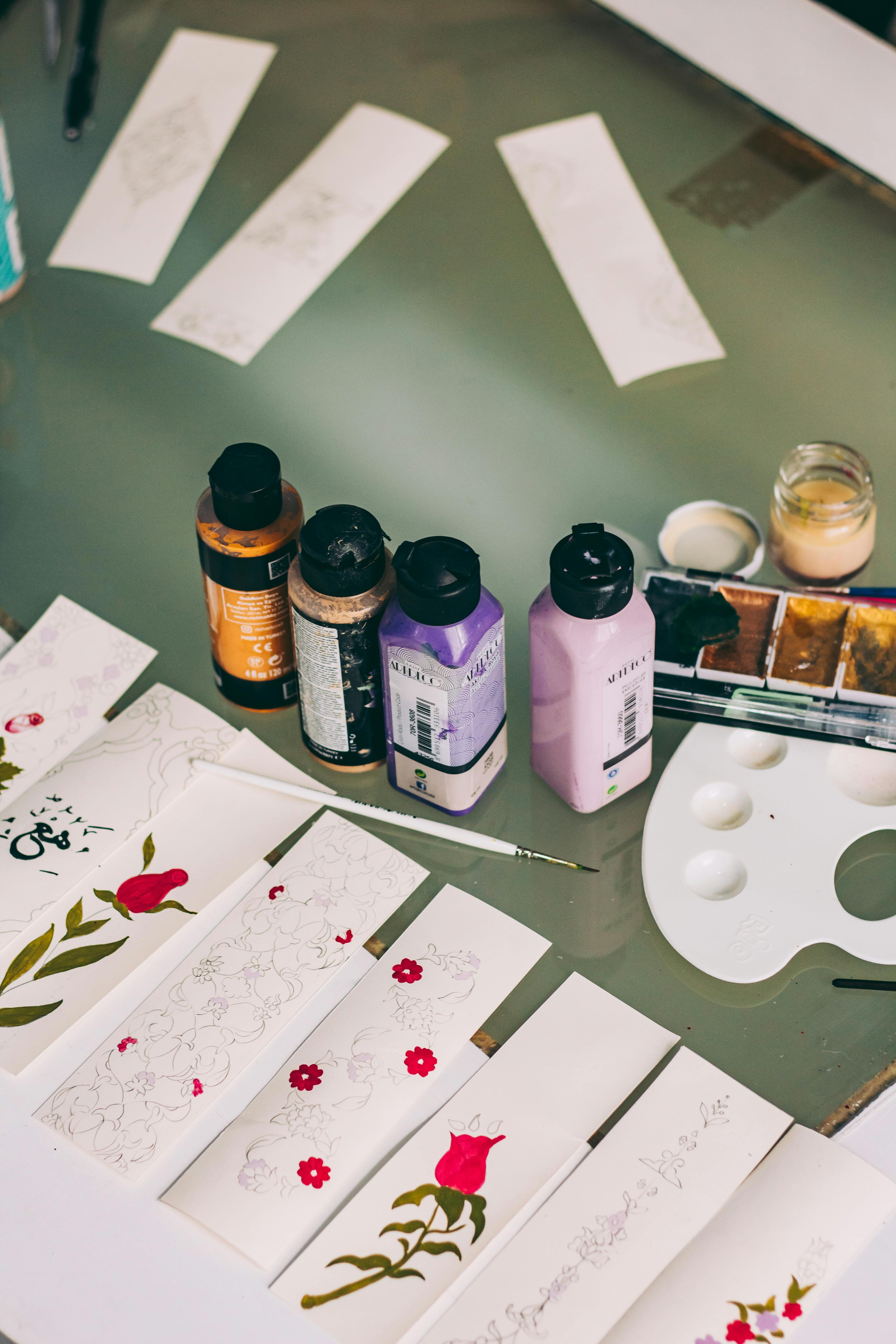 Creative Art Supplies and Floral Sketches on Desk · Free Stock Photo