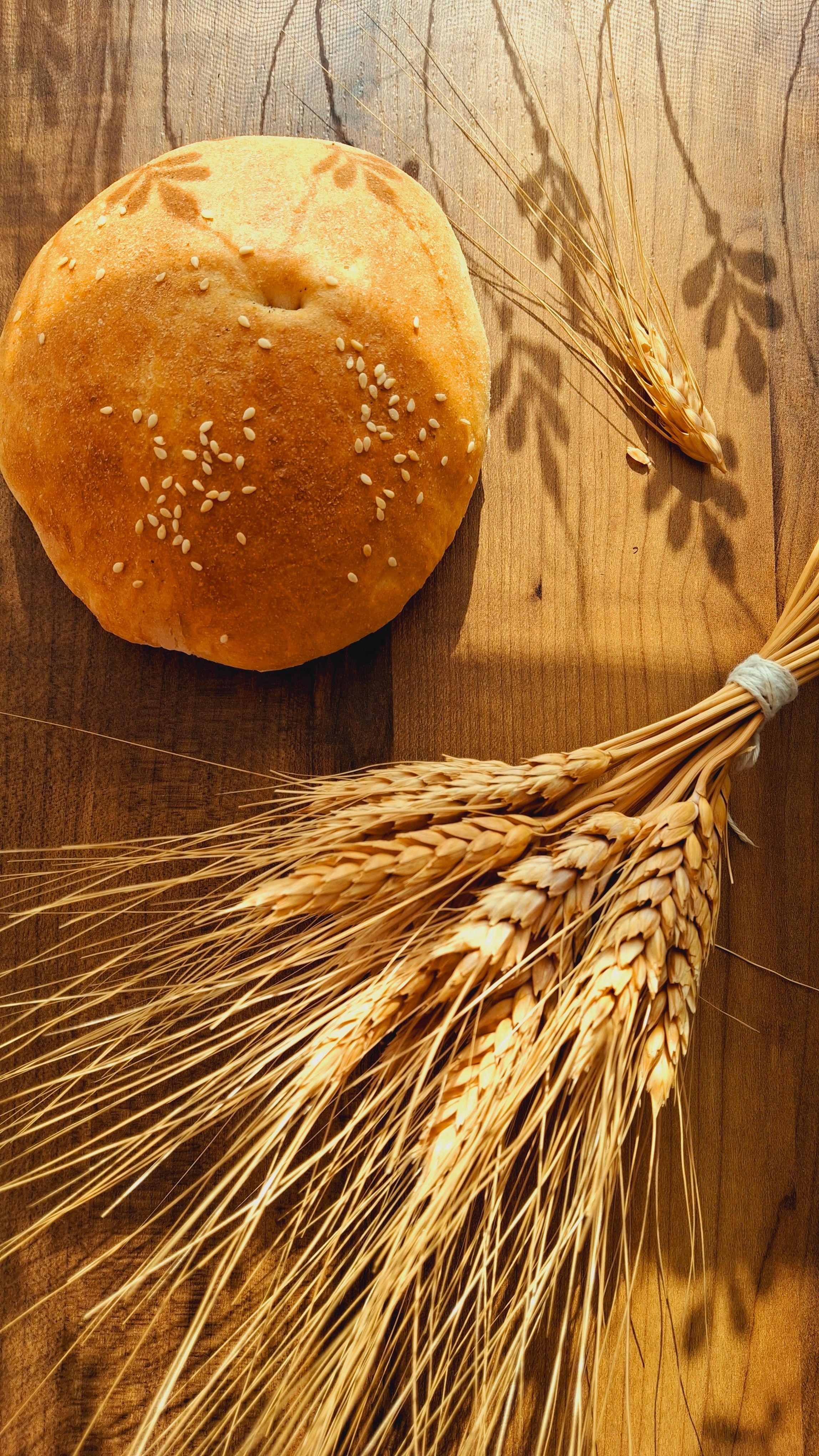 Fresh Bread Loaf with Wheat on Rustic Table · Free Stock Photo