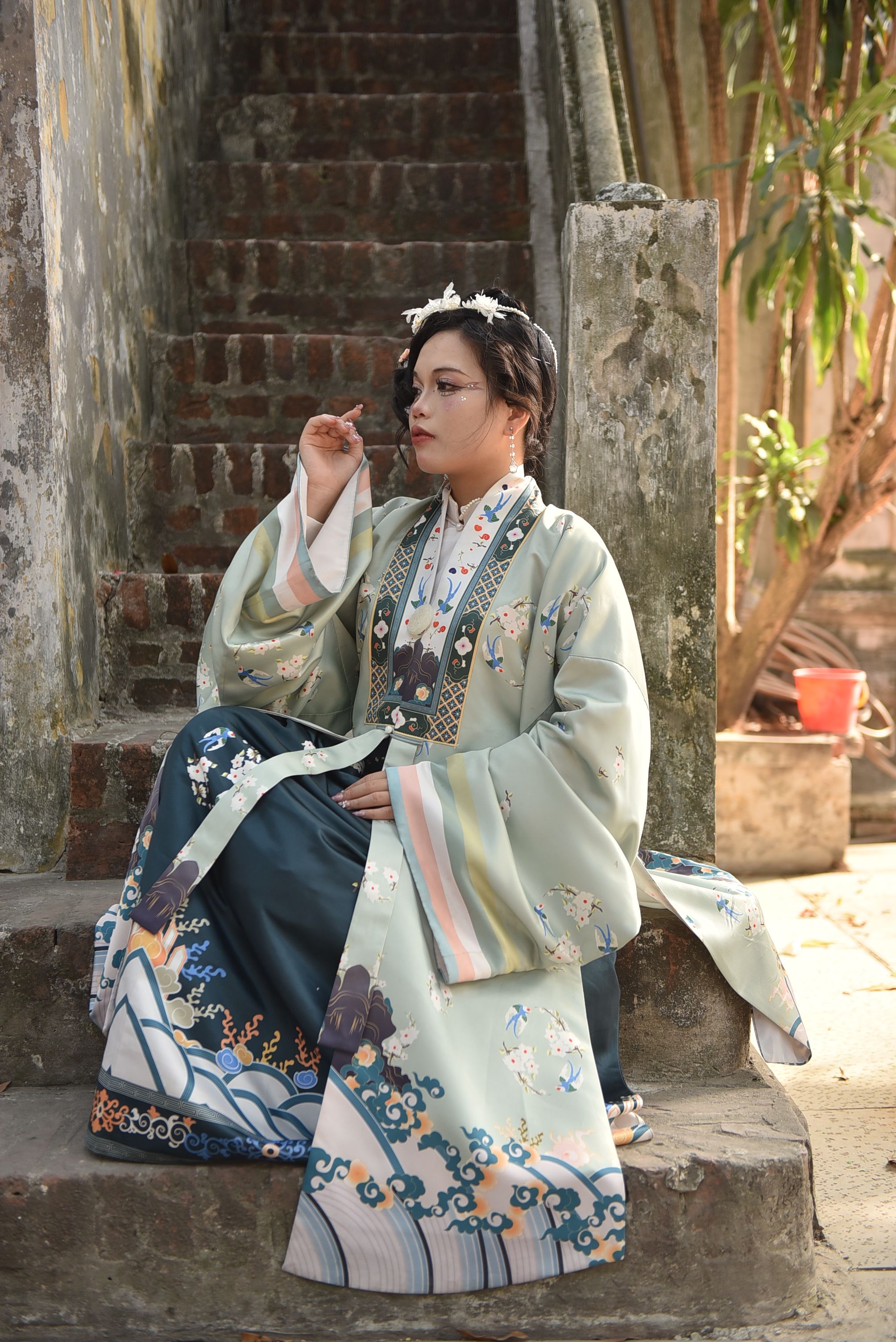 Woman in Traditional Asian Attire on Steps · Free Stock Photo