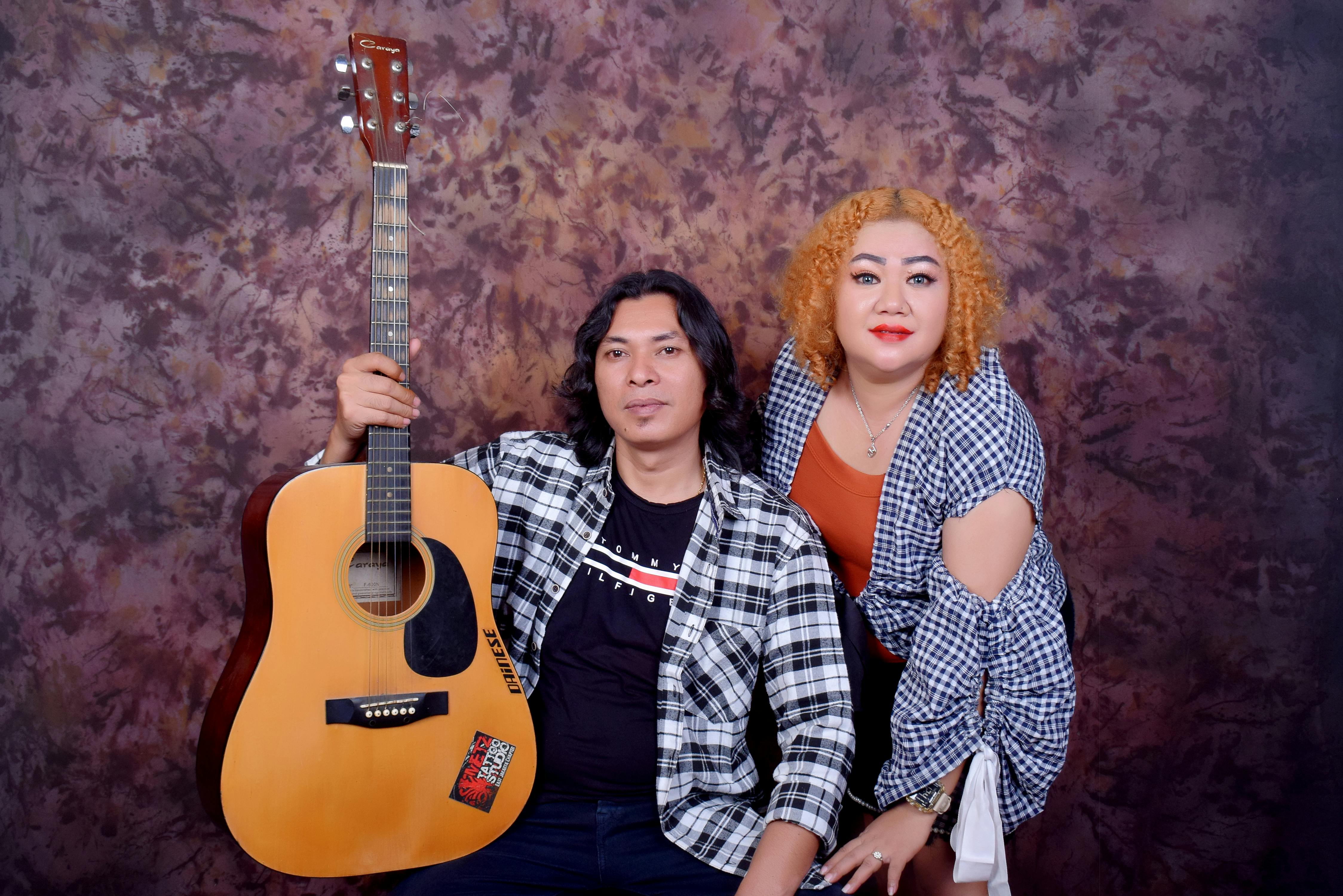 Duo Portrait with Acoustic Guitar in Studio Setting · Free Stock Photo