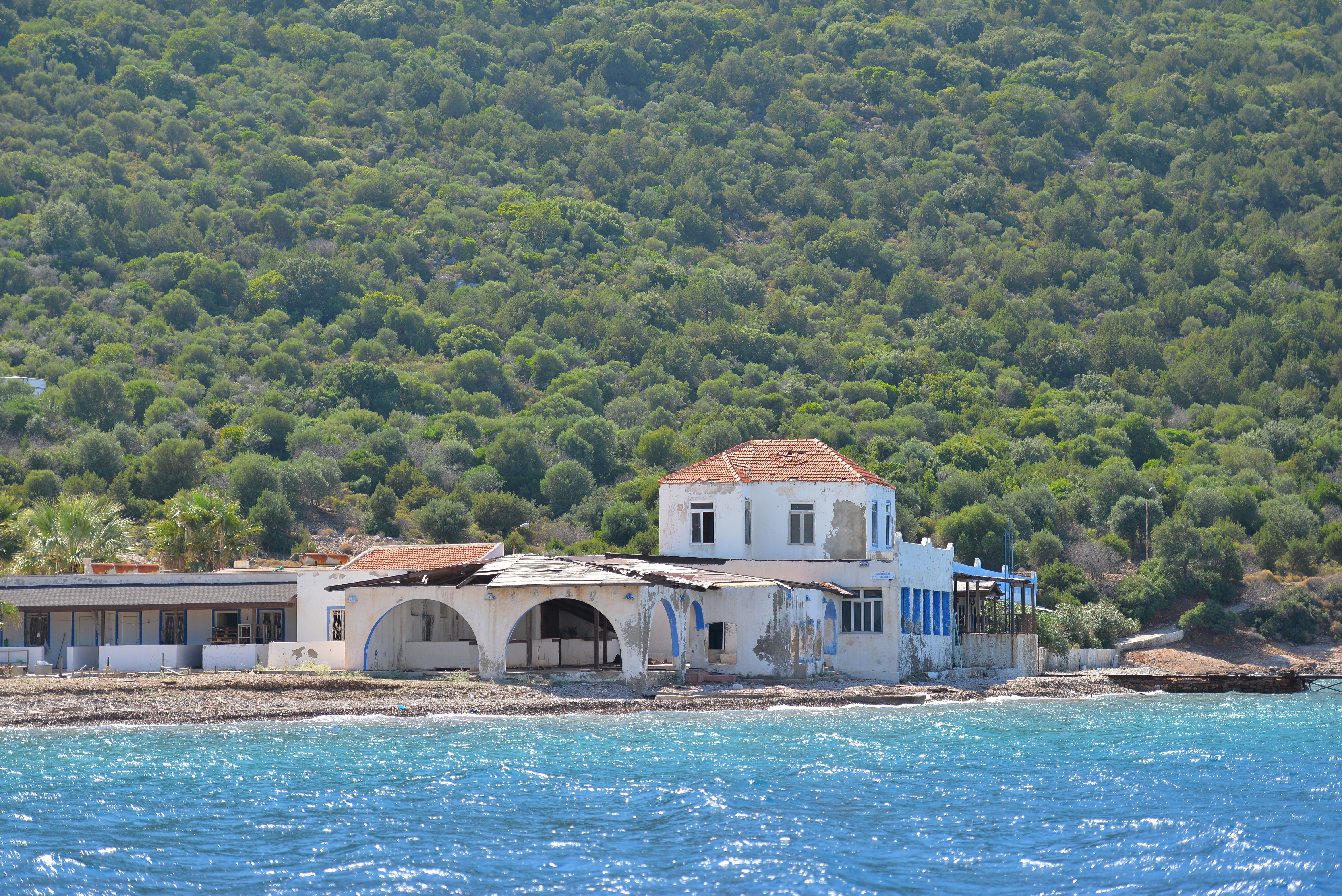 Abandoned Seaside Building with Mountain Backdrop · Free Stock Photo