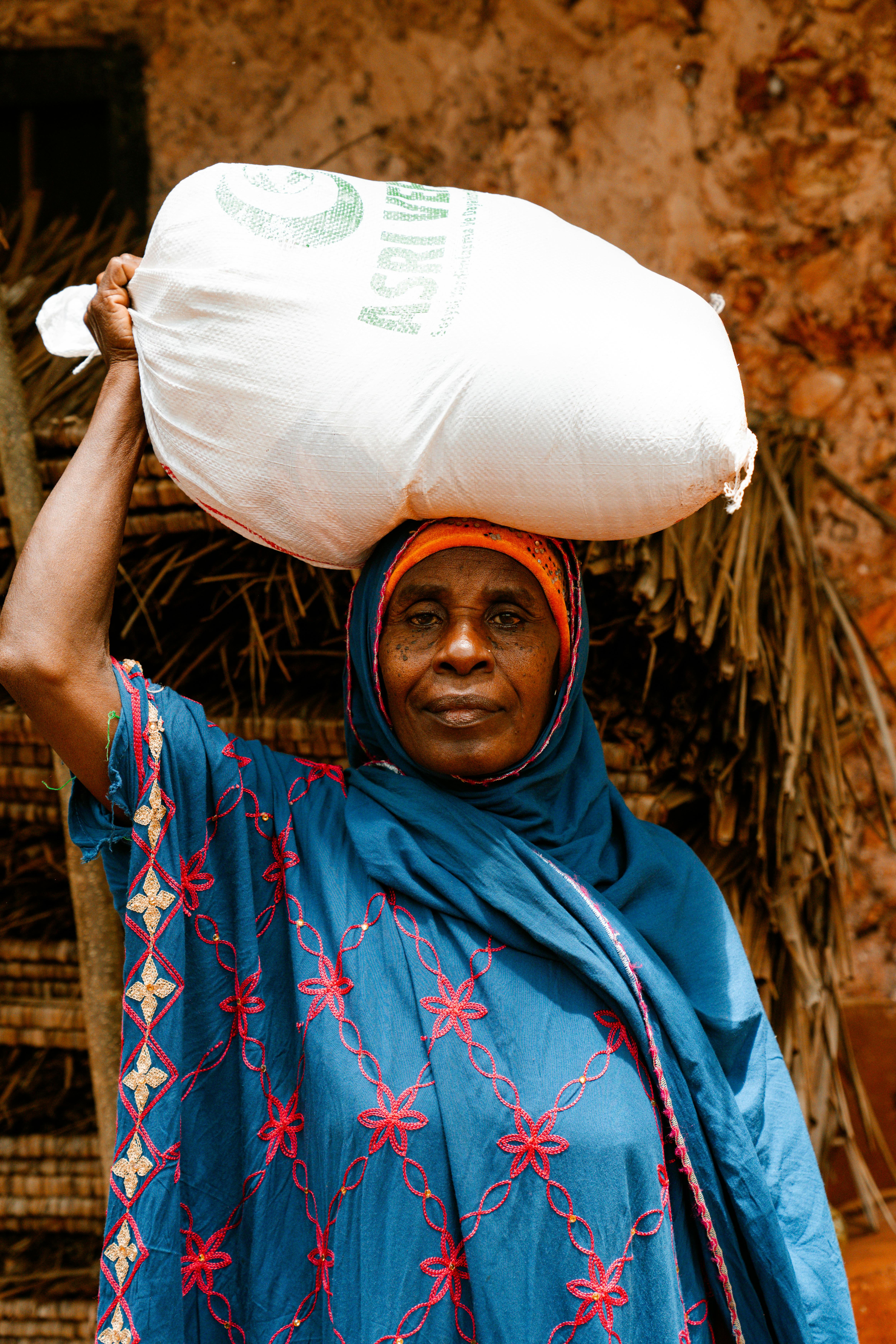 African Woman Carrying Sack in Traditional Attire · Free Stock Photo