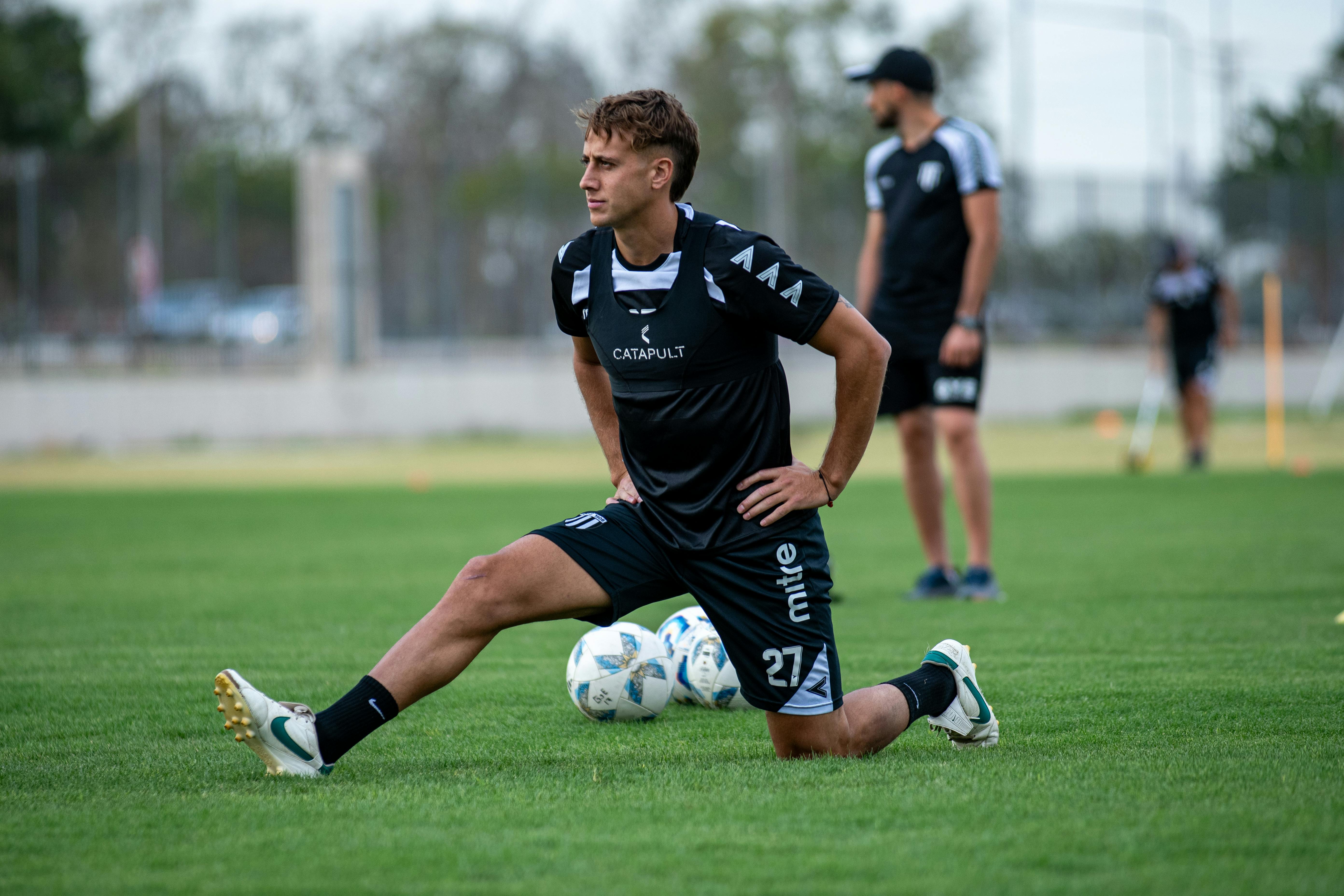 Soccer Player Stretching on Field During Training · Free Stock Photo