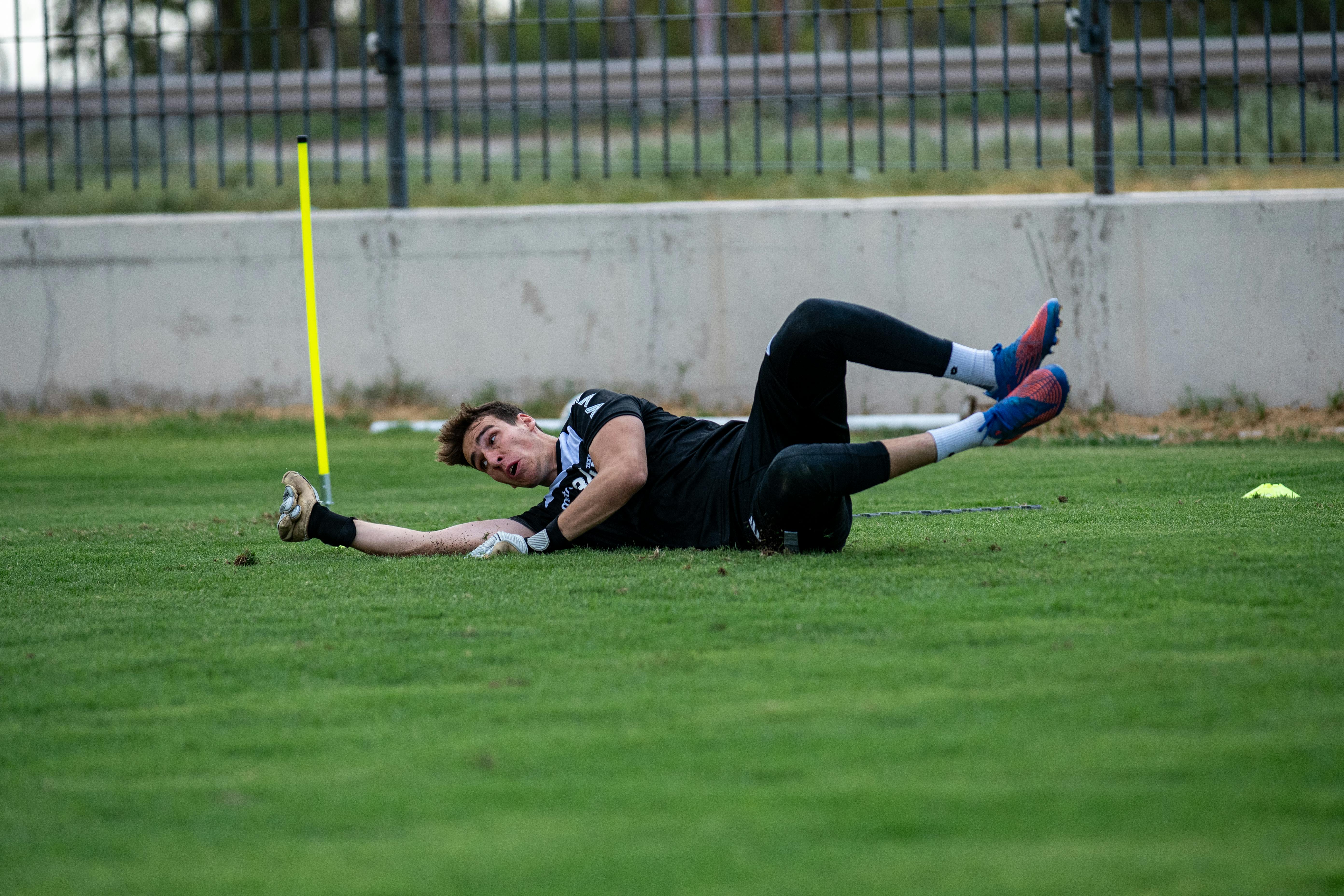Goalkeeper Leaping to Save Soccer Ball on Field · Free Stock Photo