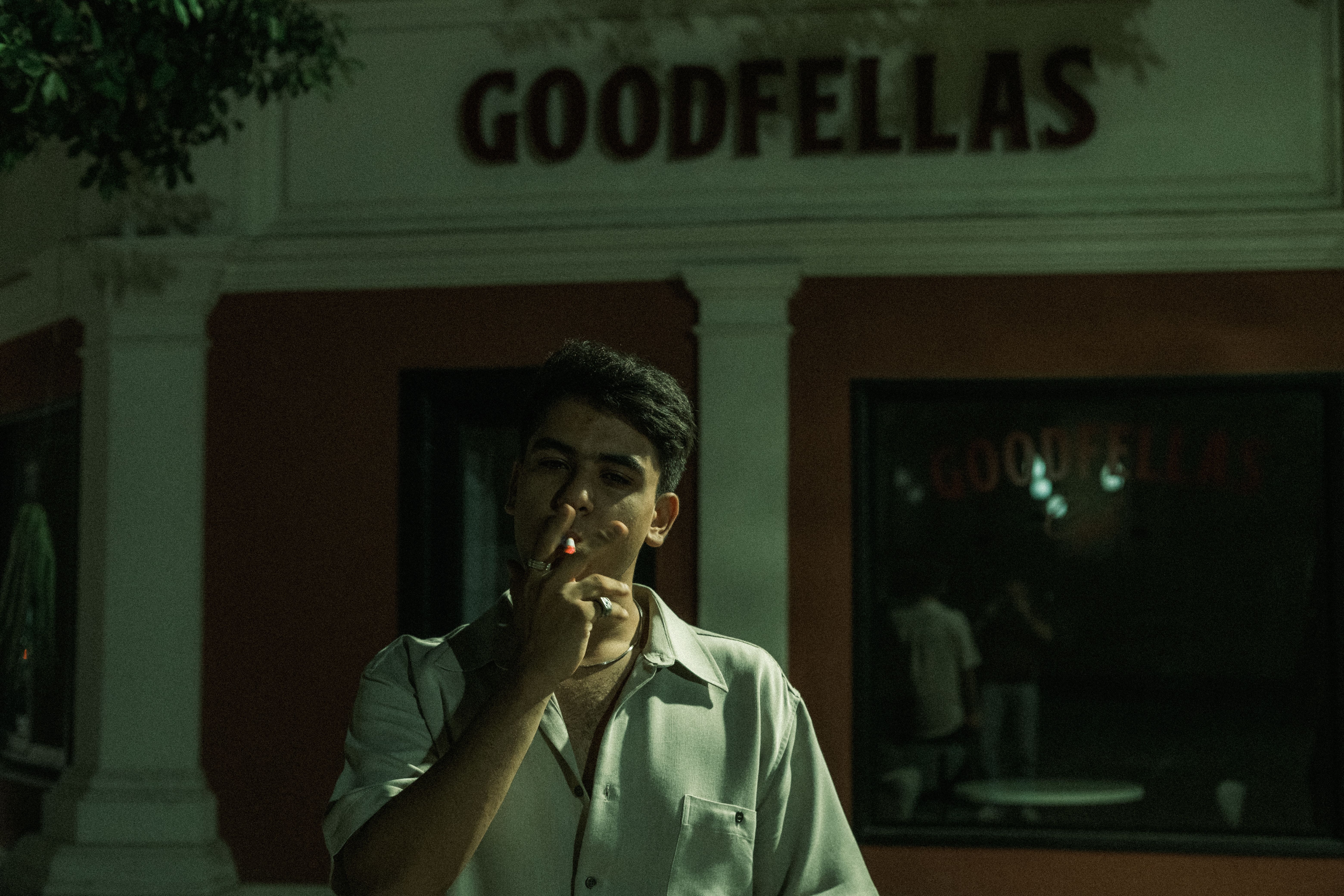 Young Man Smoking Outside a Bar at Night · Free Stock Photo